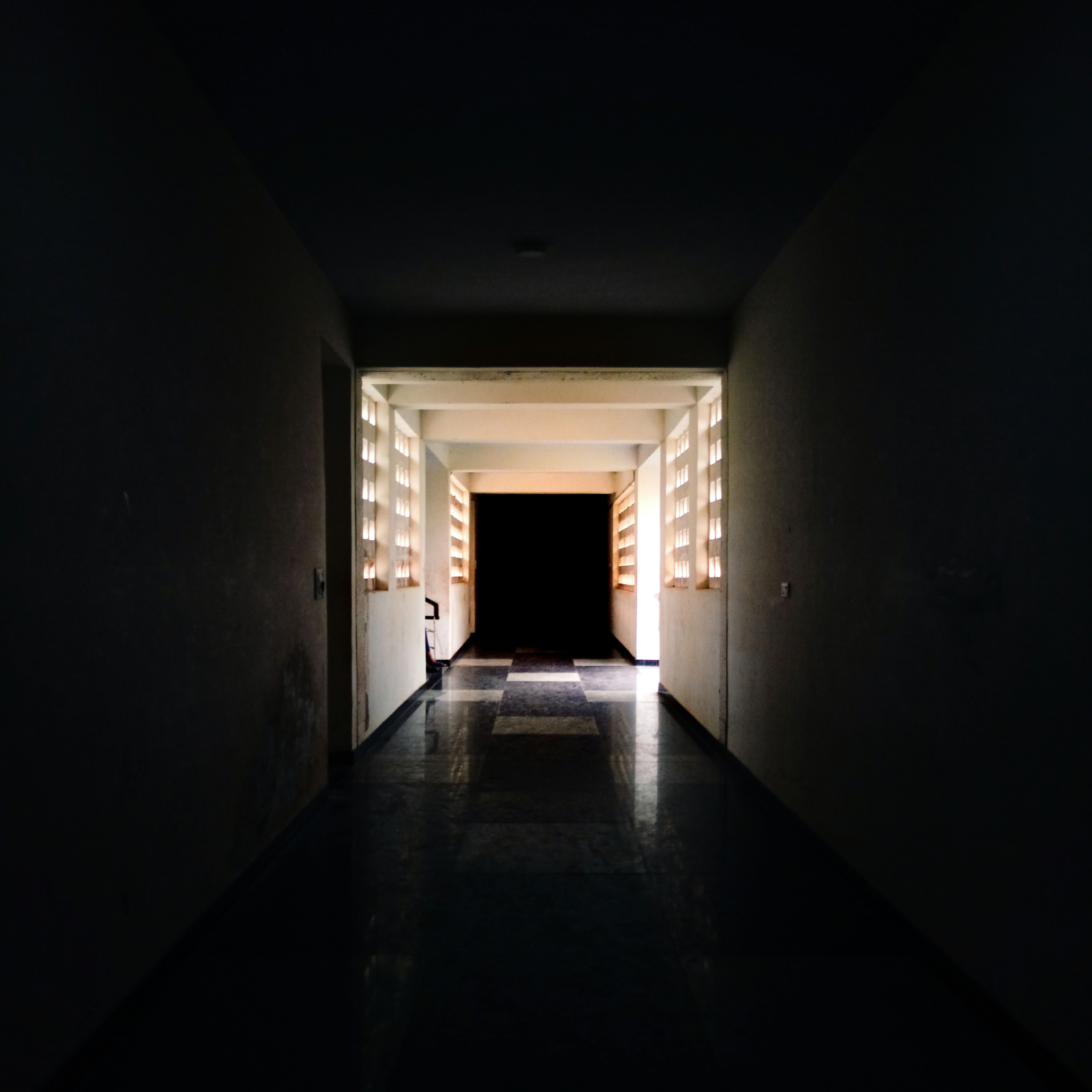 A dark hallway with light coming in from the end photo – Free Building ...