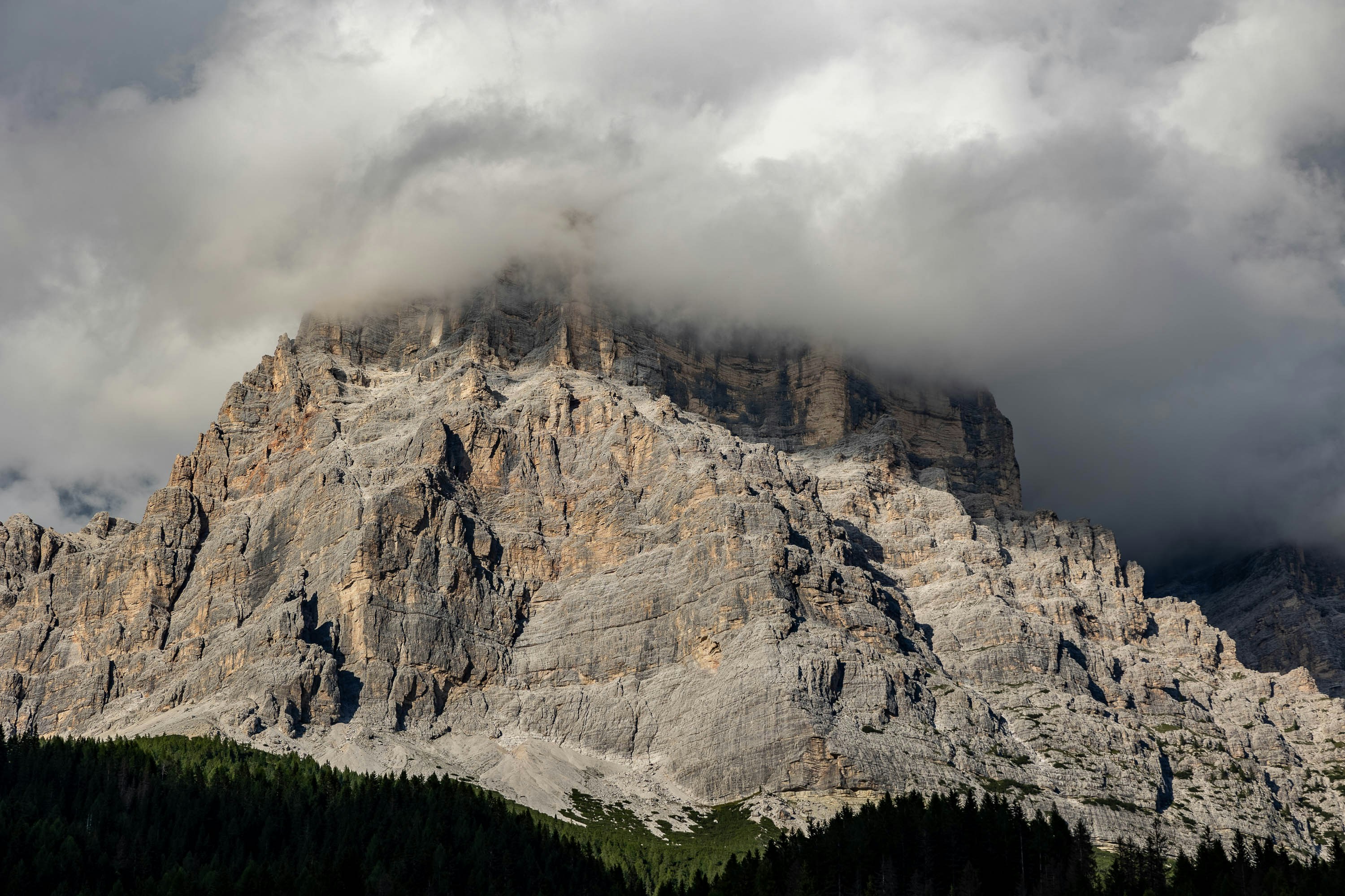 Craggy mountain summit partially shrouded by dense clouds.