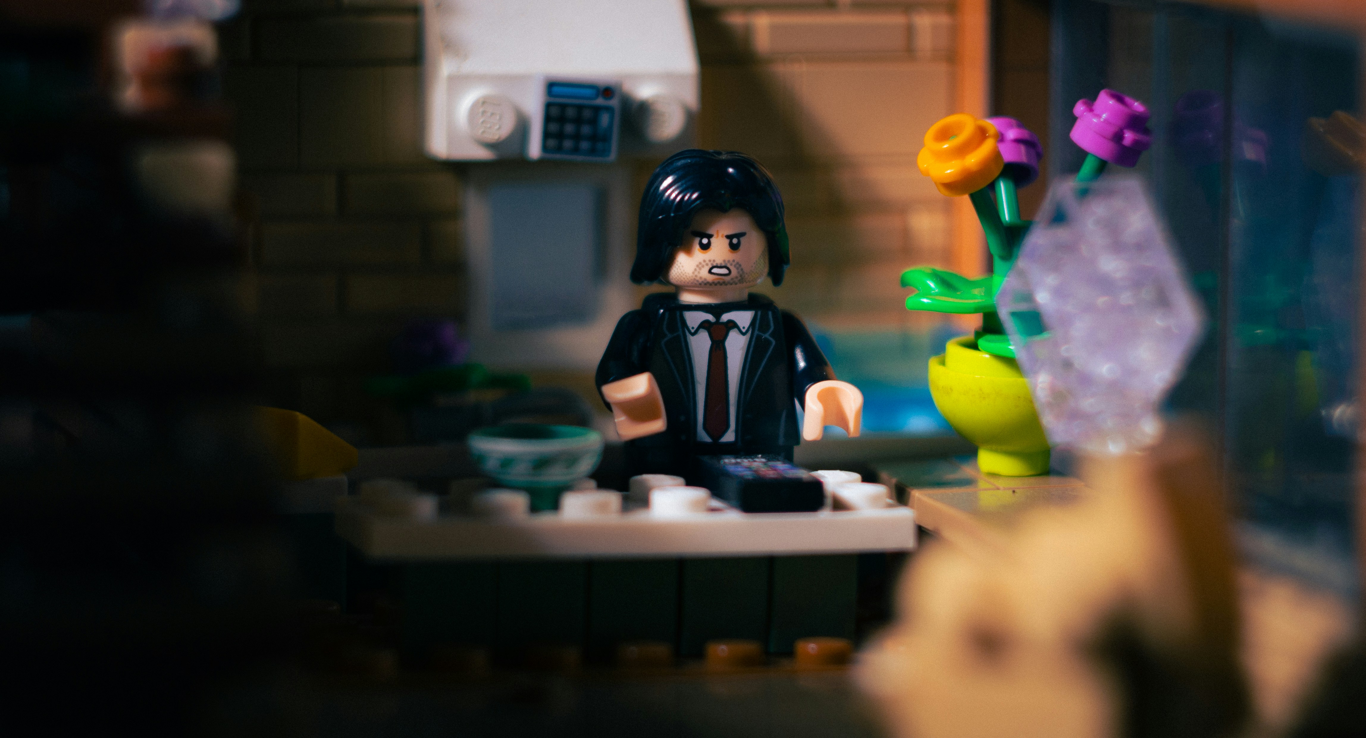 A lego man sitting on a table with flowers in a vase photo – Free Lego ...