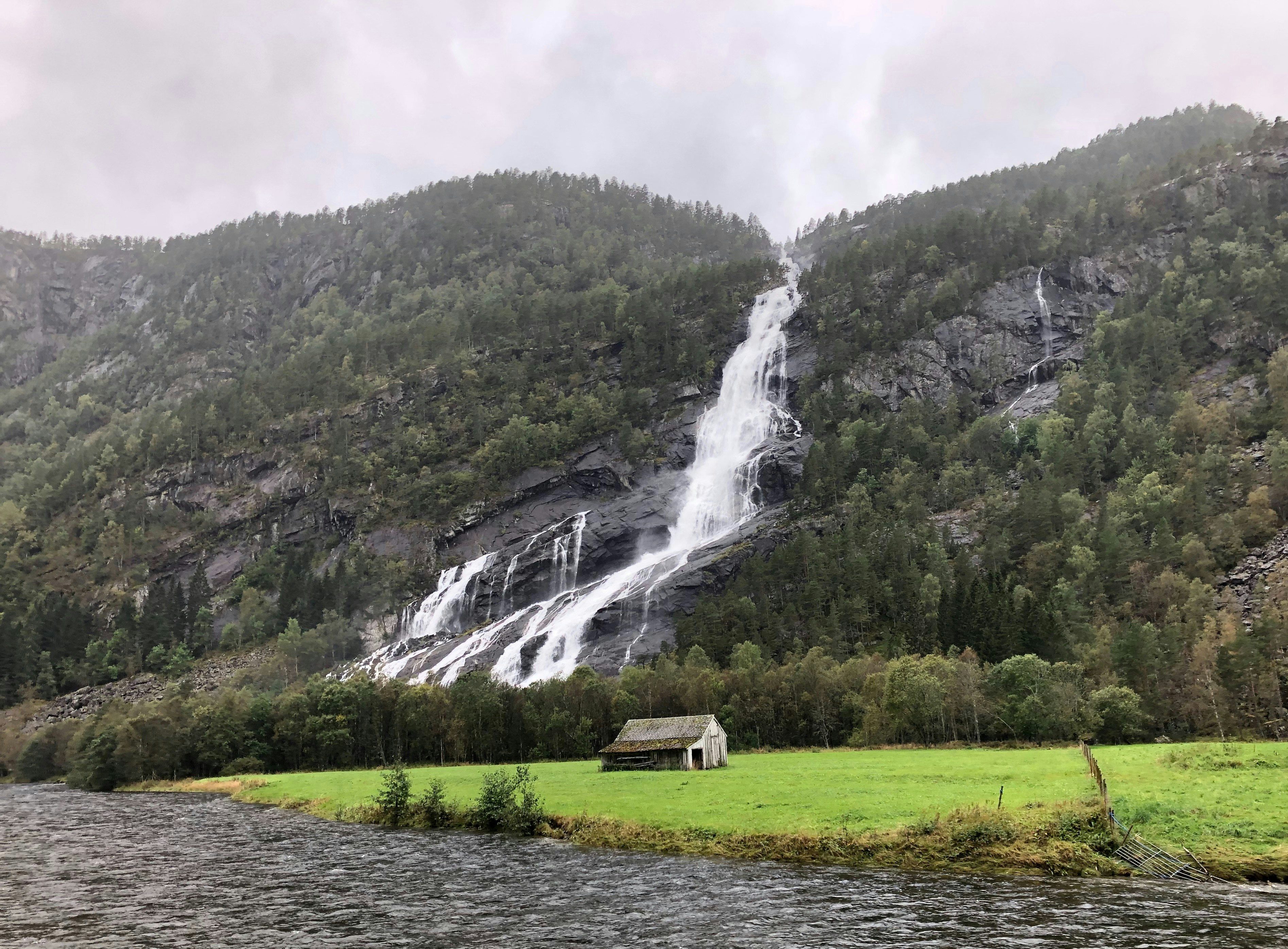 Alpine Cascade Over a Quiet Lakefront Cottage