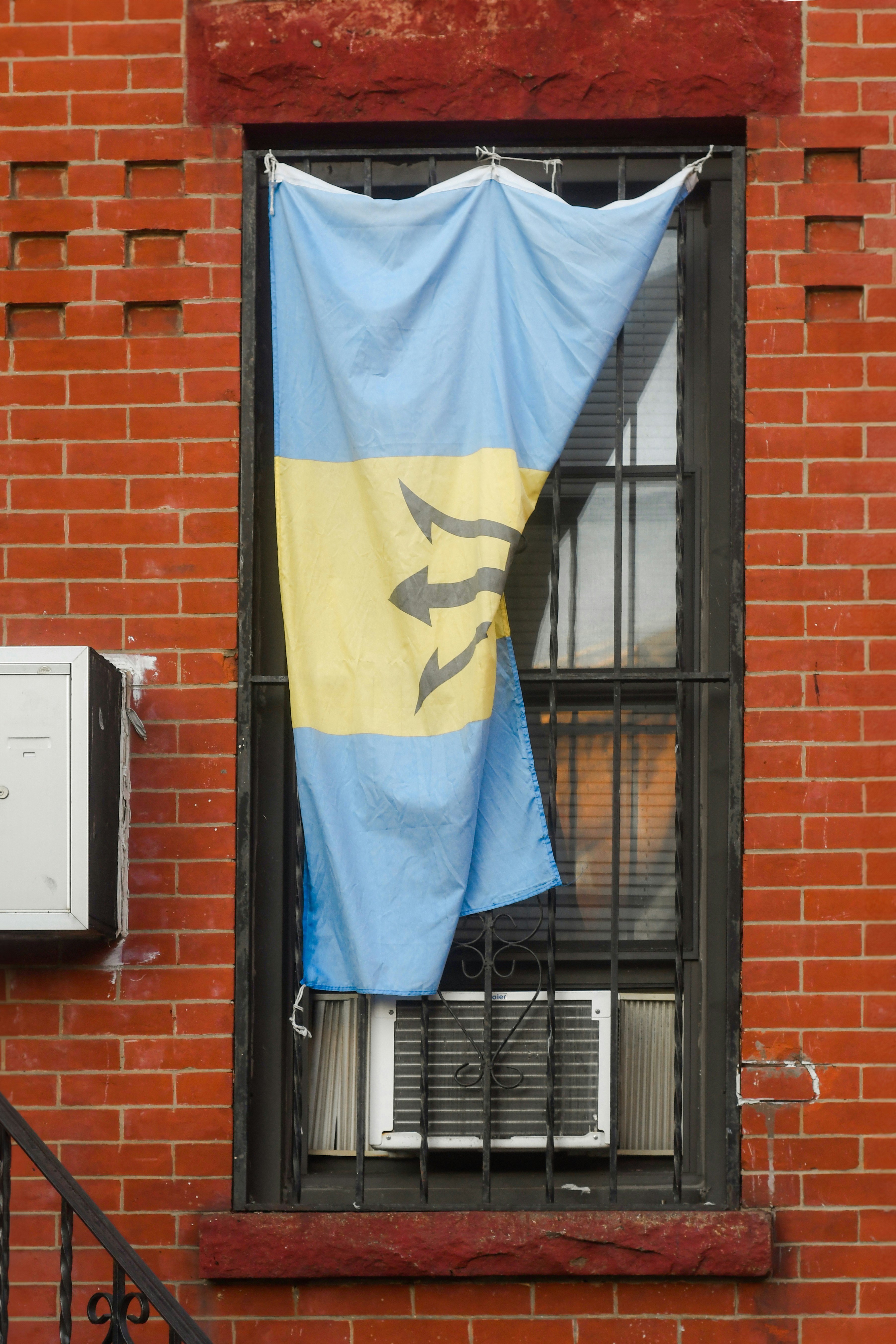 A blue and yellow flag hanging out of a window photo – Free Flag Image ...