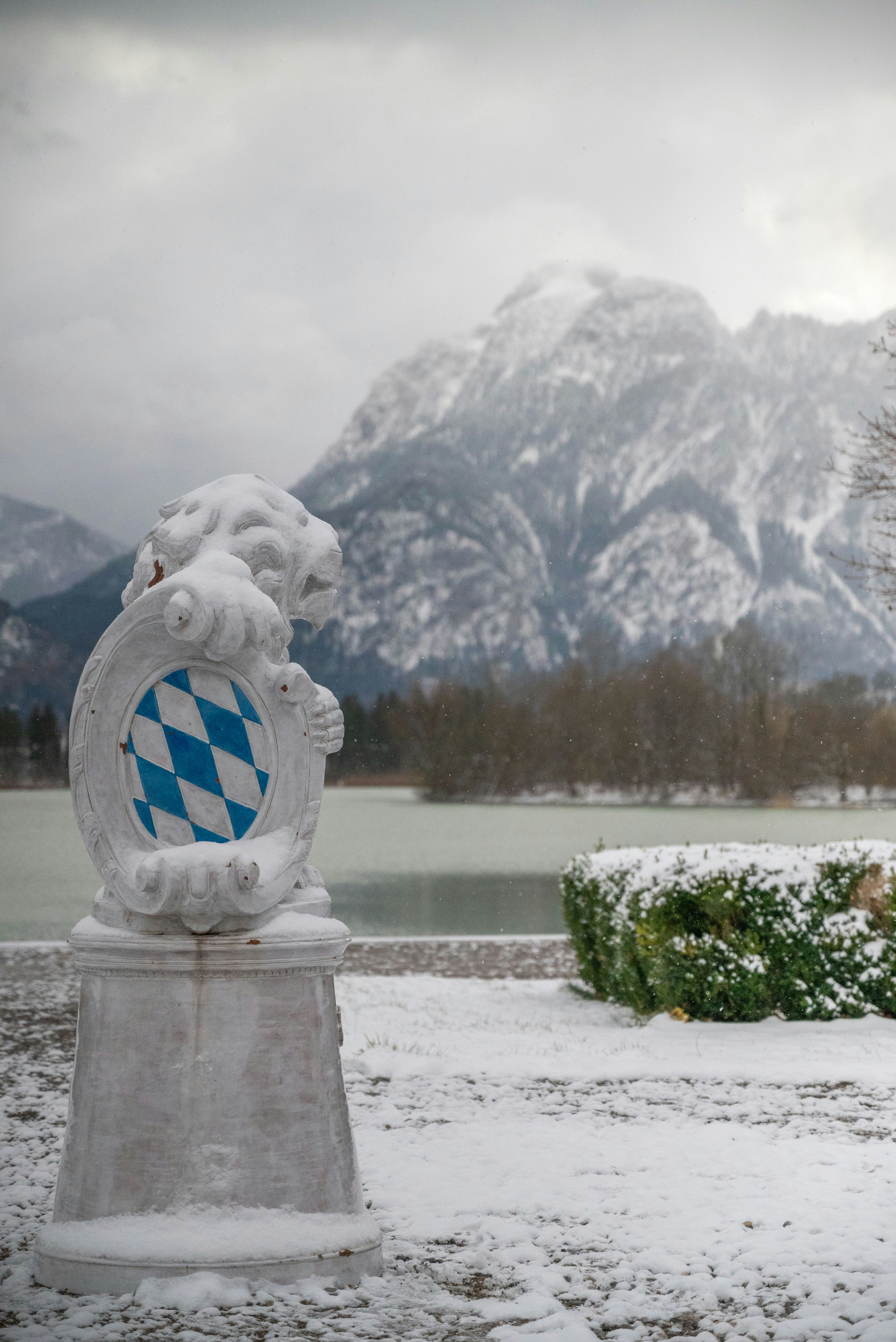 Snowy Bavarian Crest: A Stone Shield Watching Over Still Waters