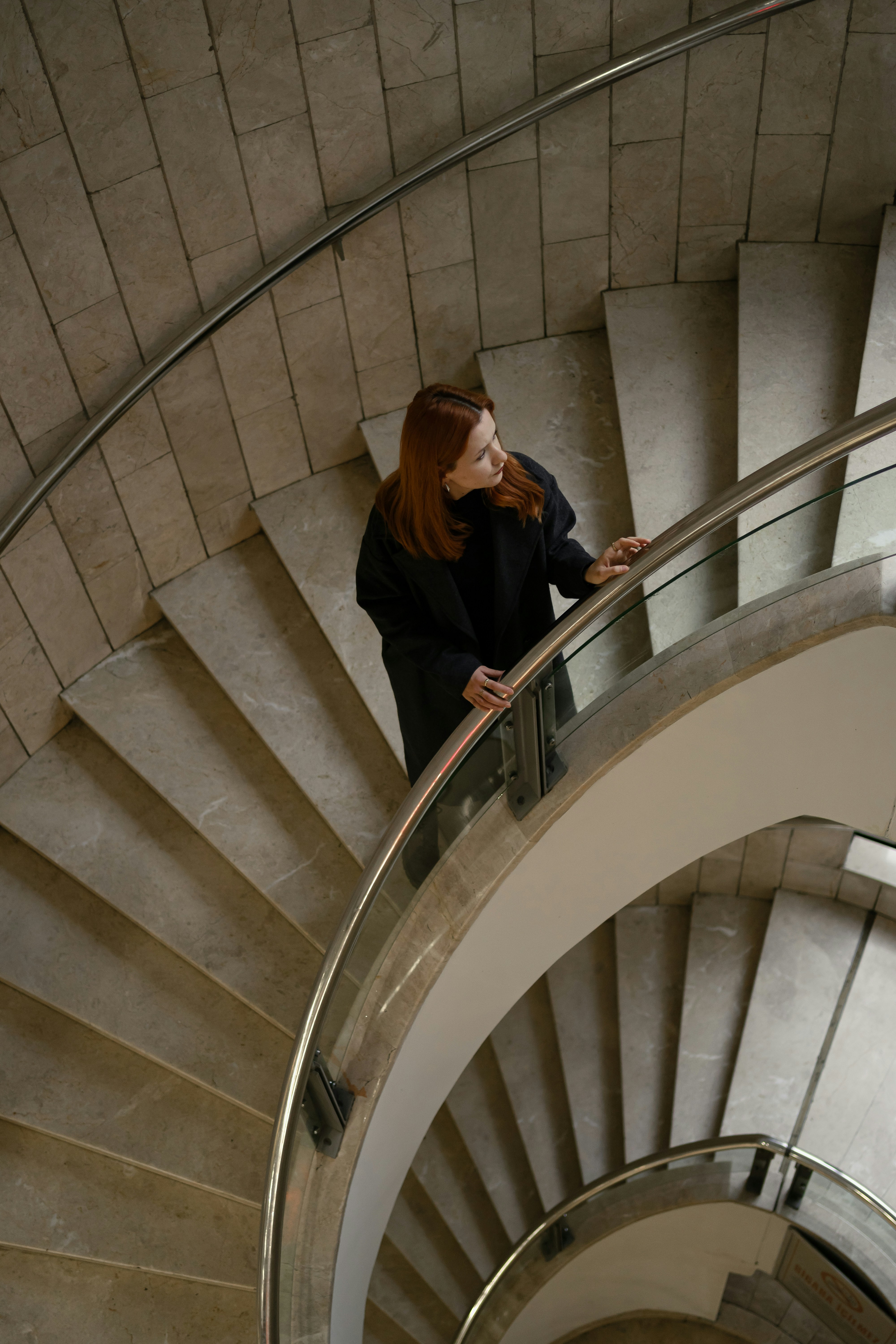 Redhead on a Marble Spiral: A Quiet Portrait on the Circular Staircase