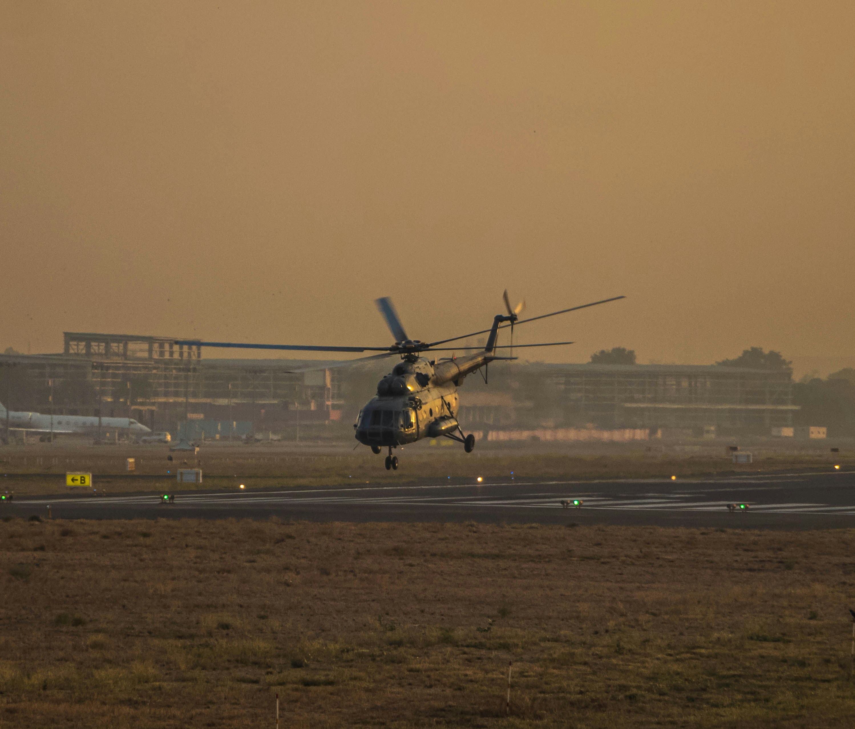 Dusk Hover: A Helicopter Touches Down on a Quiet Airport Runway