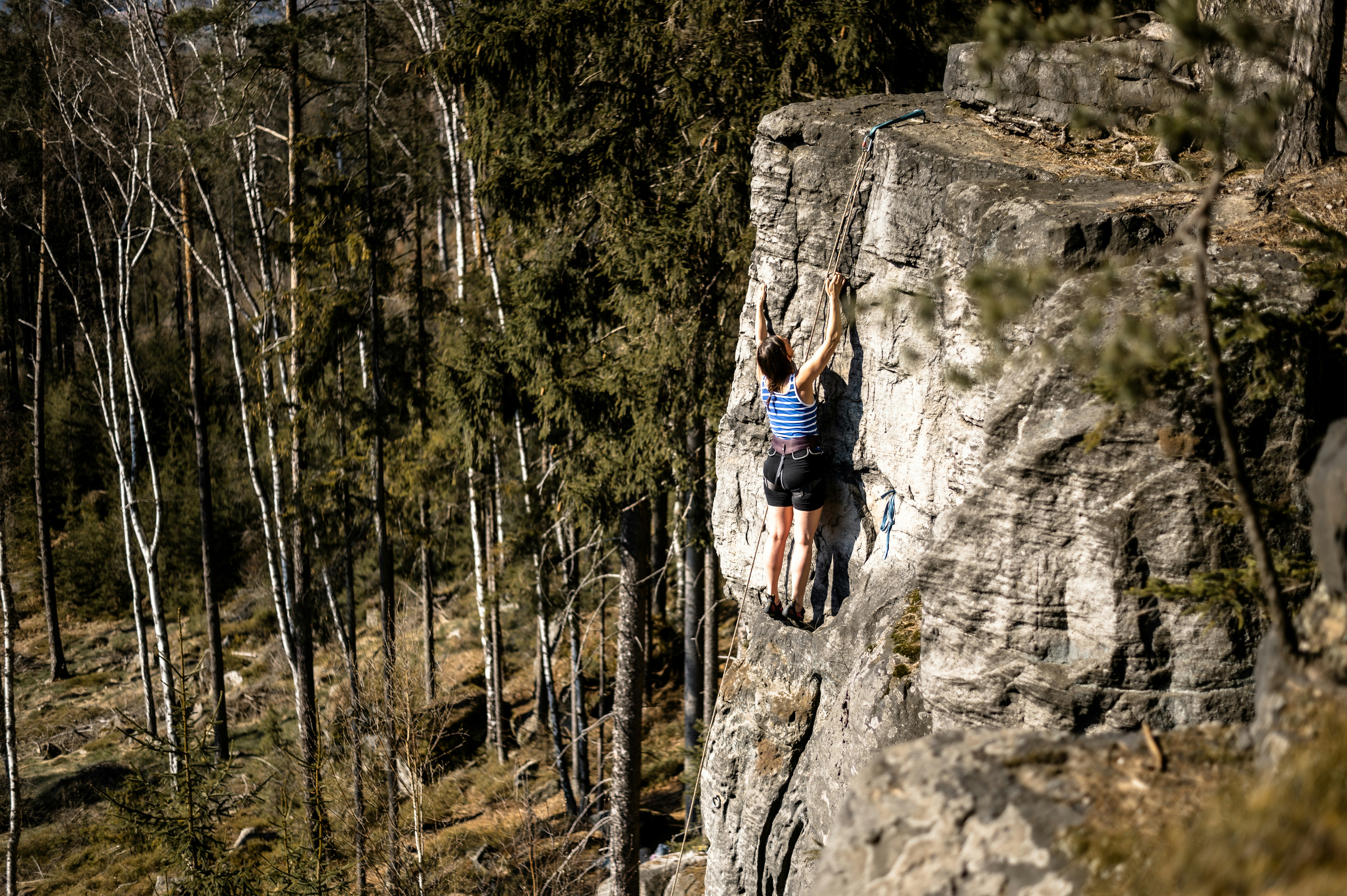 Edge of Resolve: Climber suspended on a sunlit limestone cliff