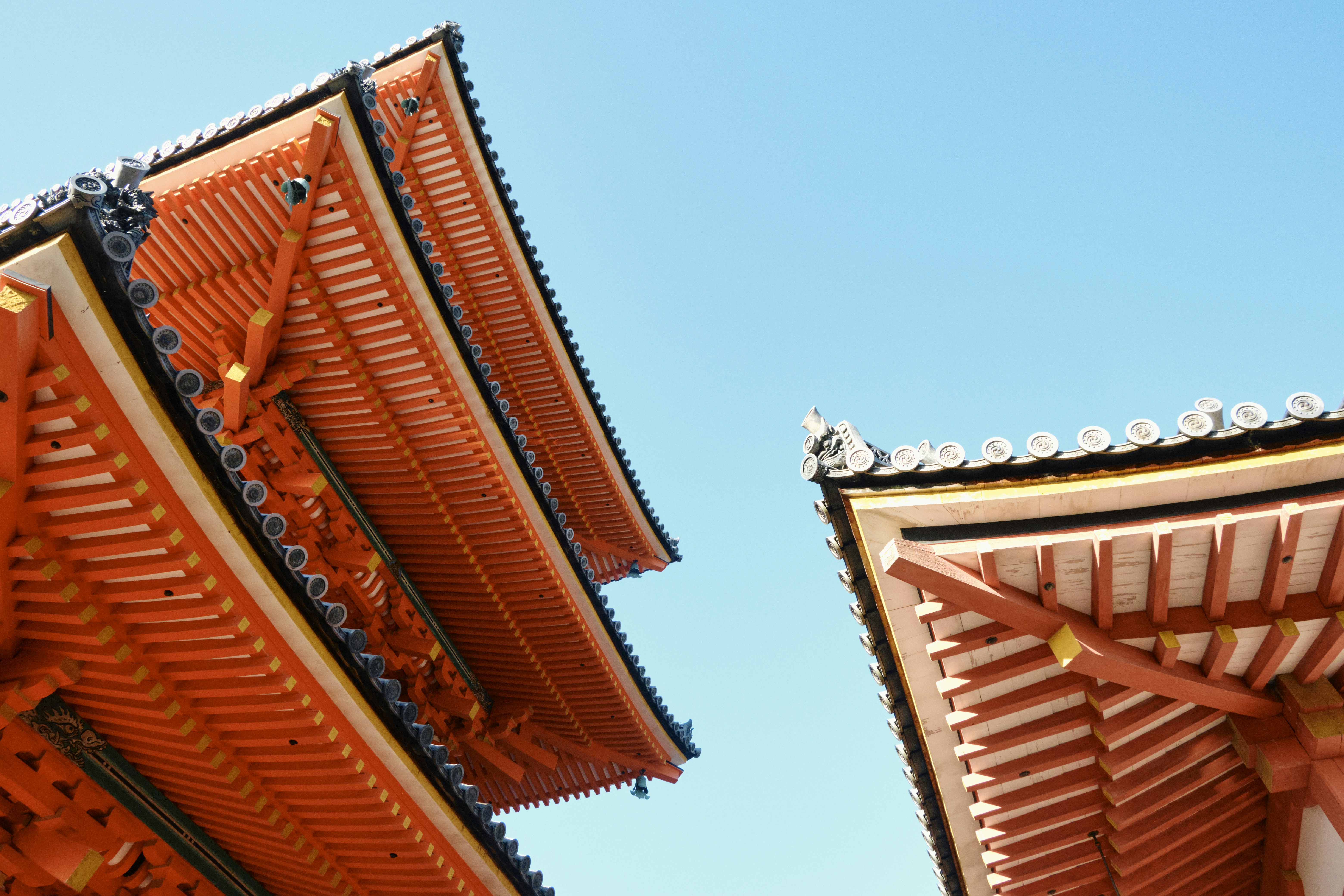 Lacquered Eaves: Orange Timber Angles Against a Cerulean Sky