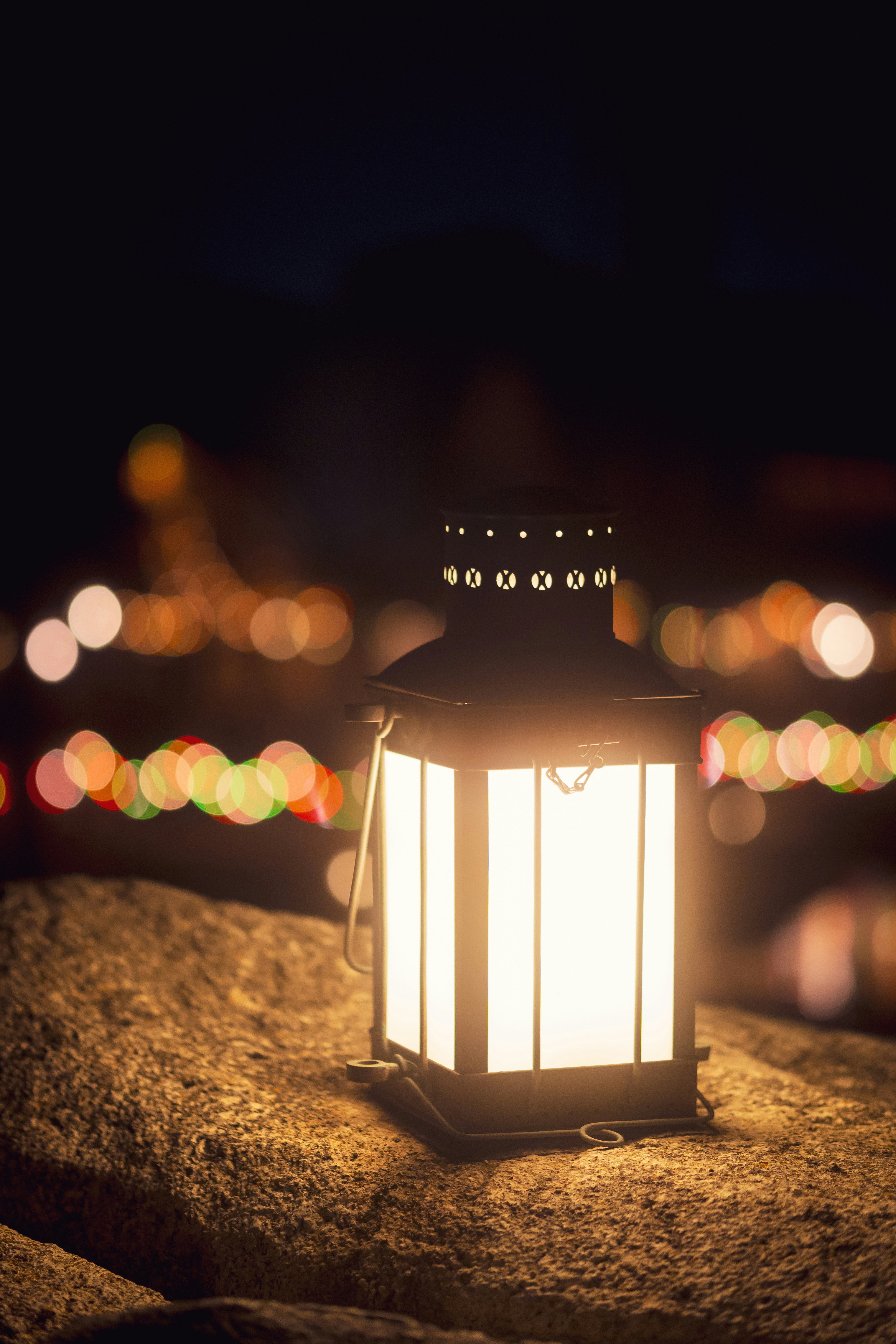 A lit lantern sitting on top of a rock photo – Free Winter Image on ...