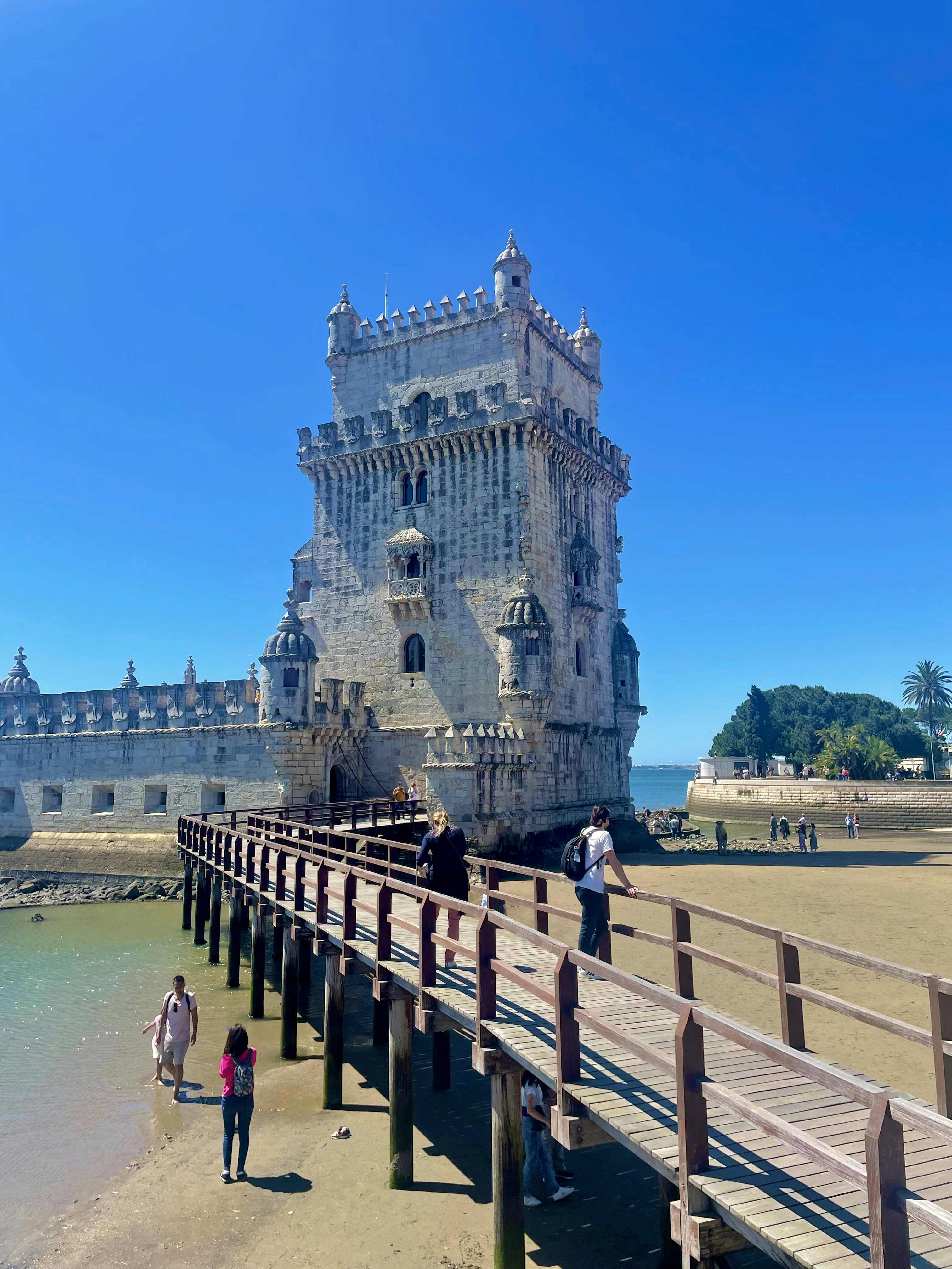 Beacon over the Atlantic: Belém Tower from a sunlit wooden causeway