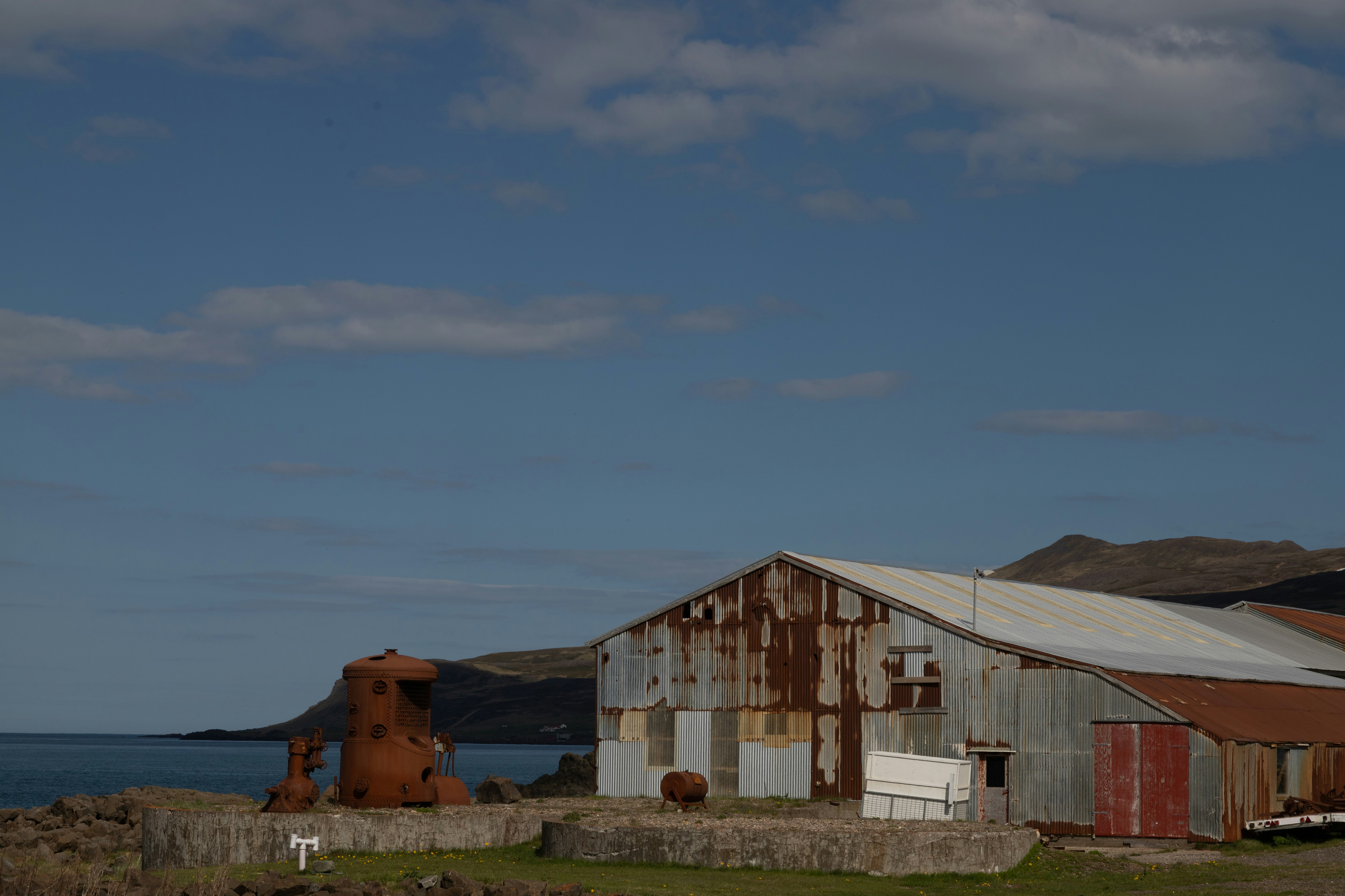 A rusted out building next to a body of water photo – Free Building ...