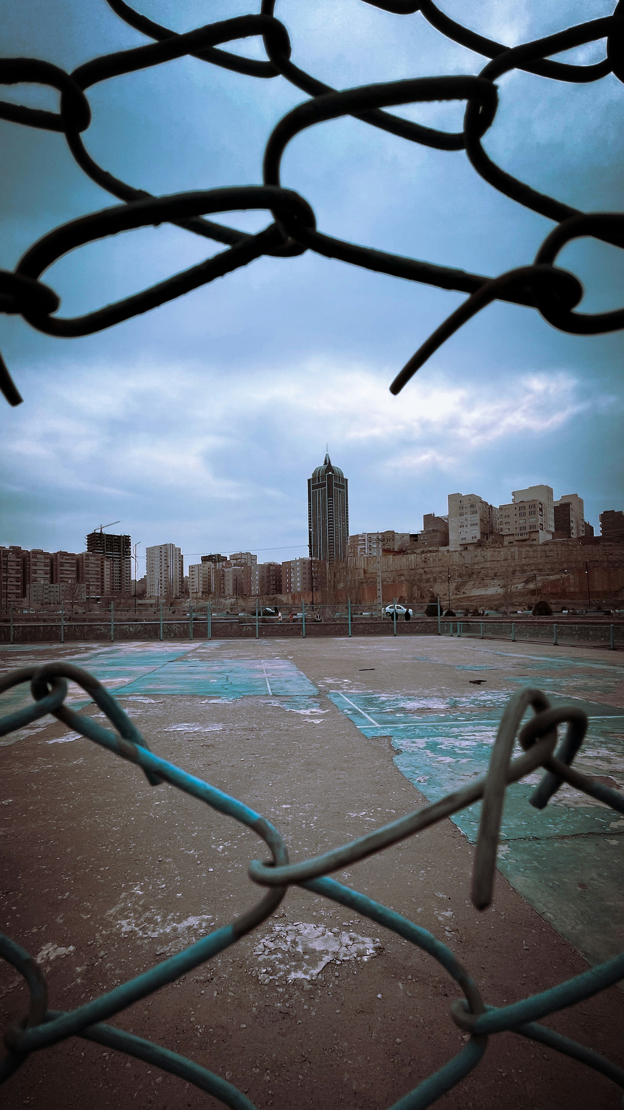 Between Chains and Skyscrapers: A City Framed by Barbed Mesh