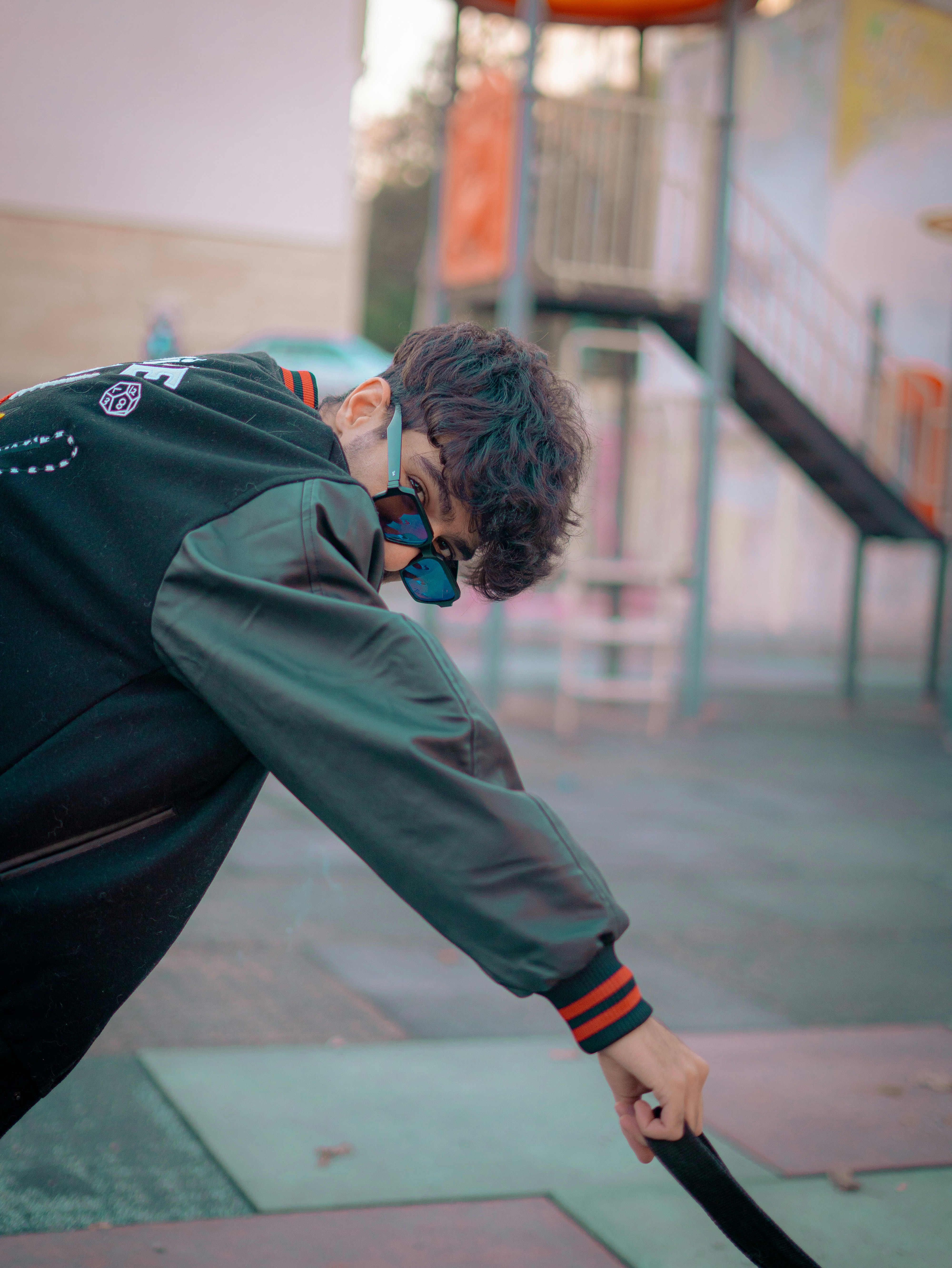 A man bending over to pick up something off the ground photo – Free ...