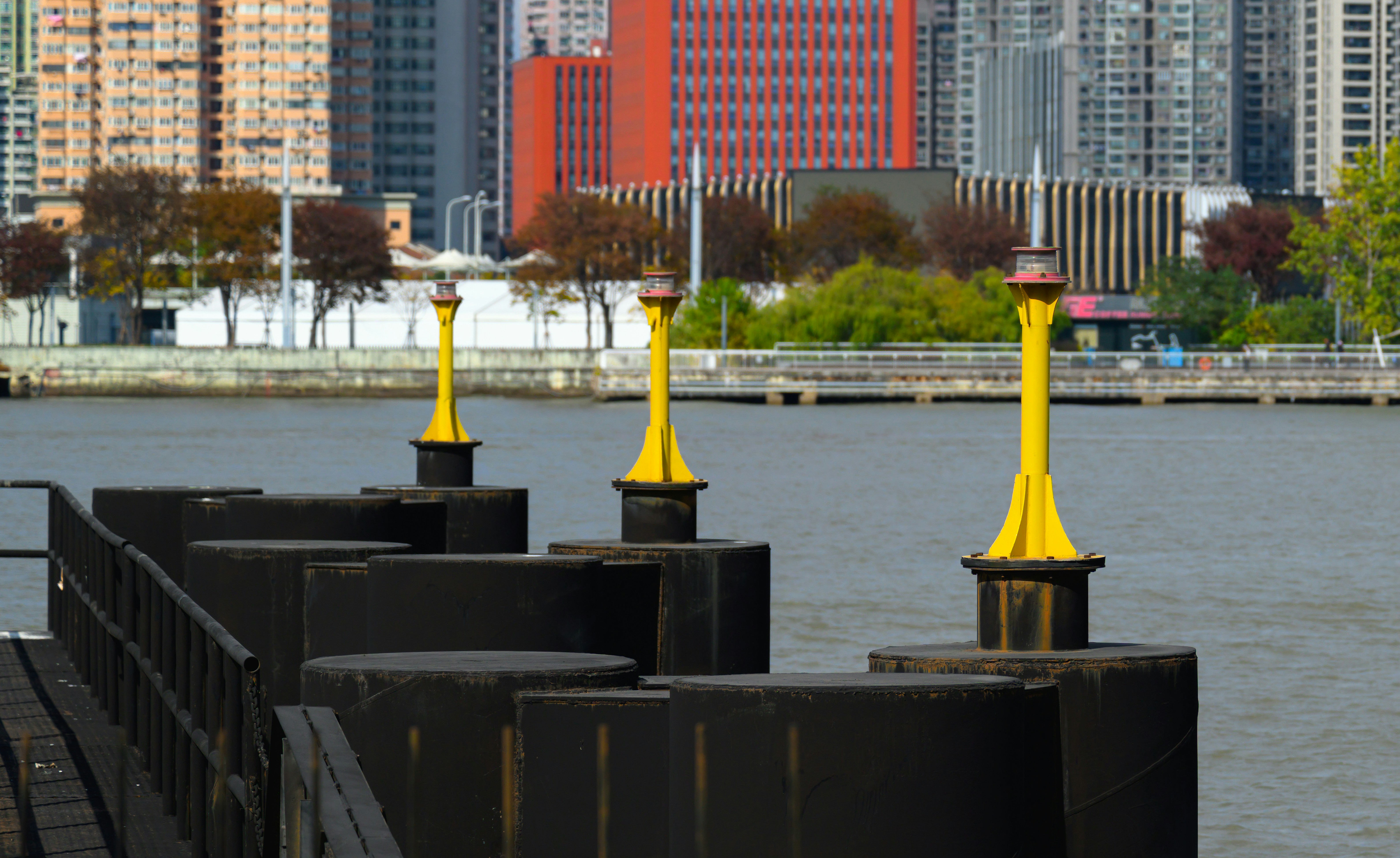 Harbor Pylons at Dusk: Yellow Markers Against Urban Wake