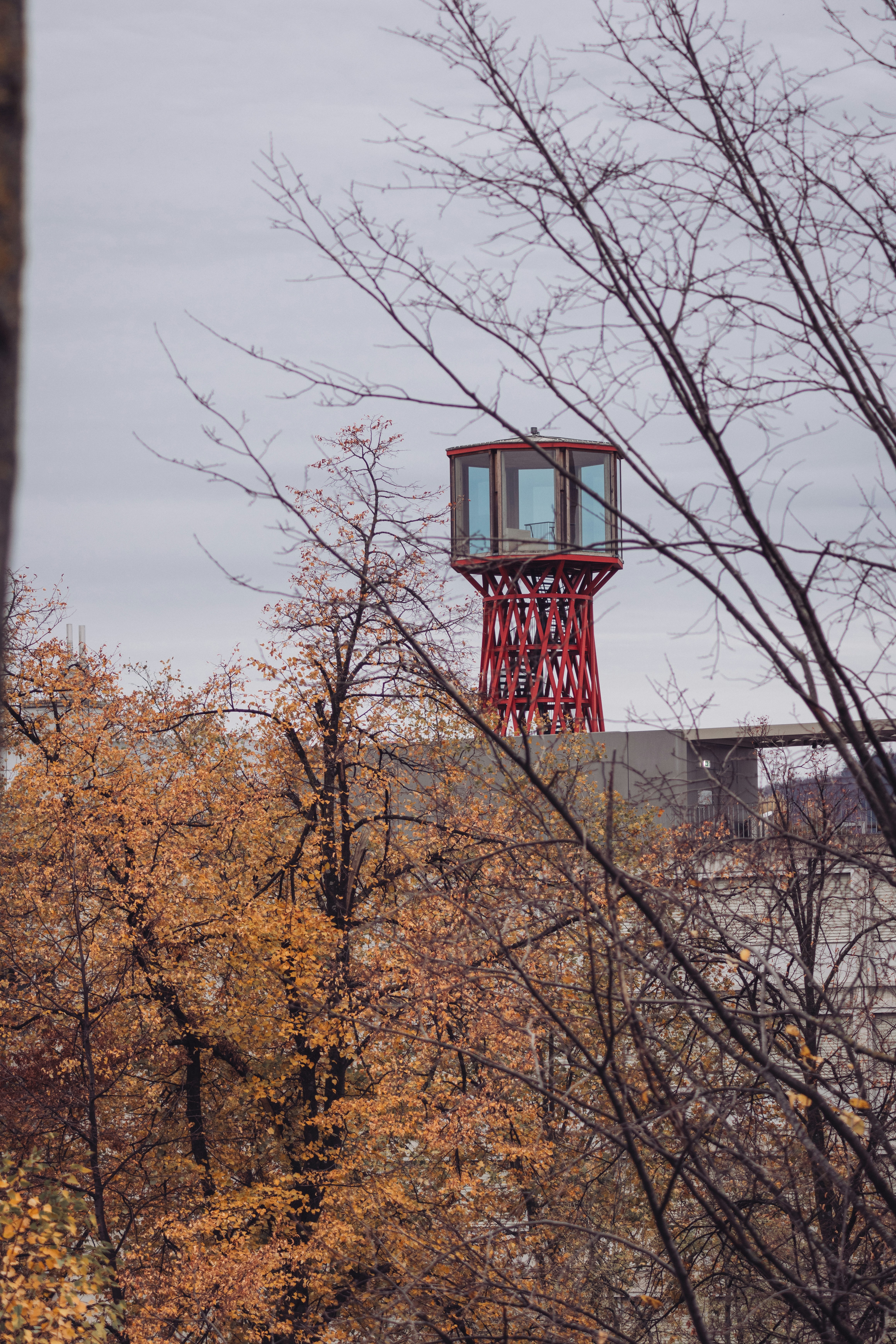 a tall red tower with a clock on top of it