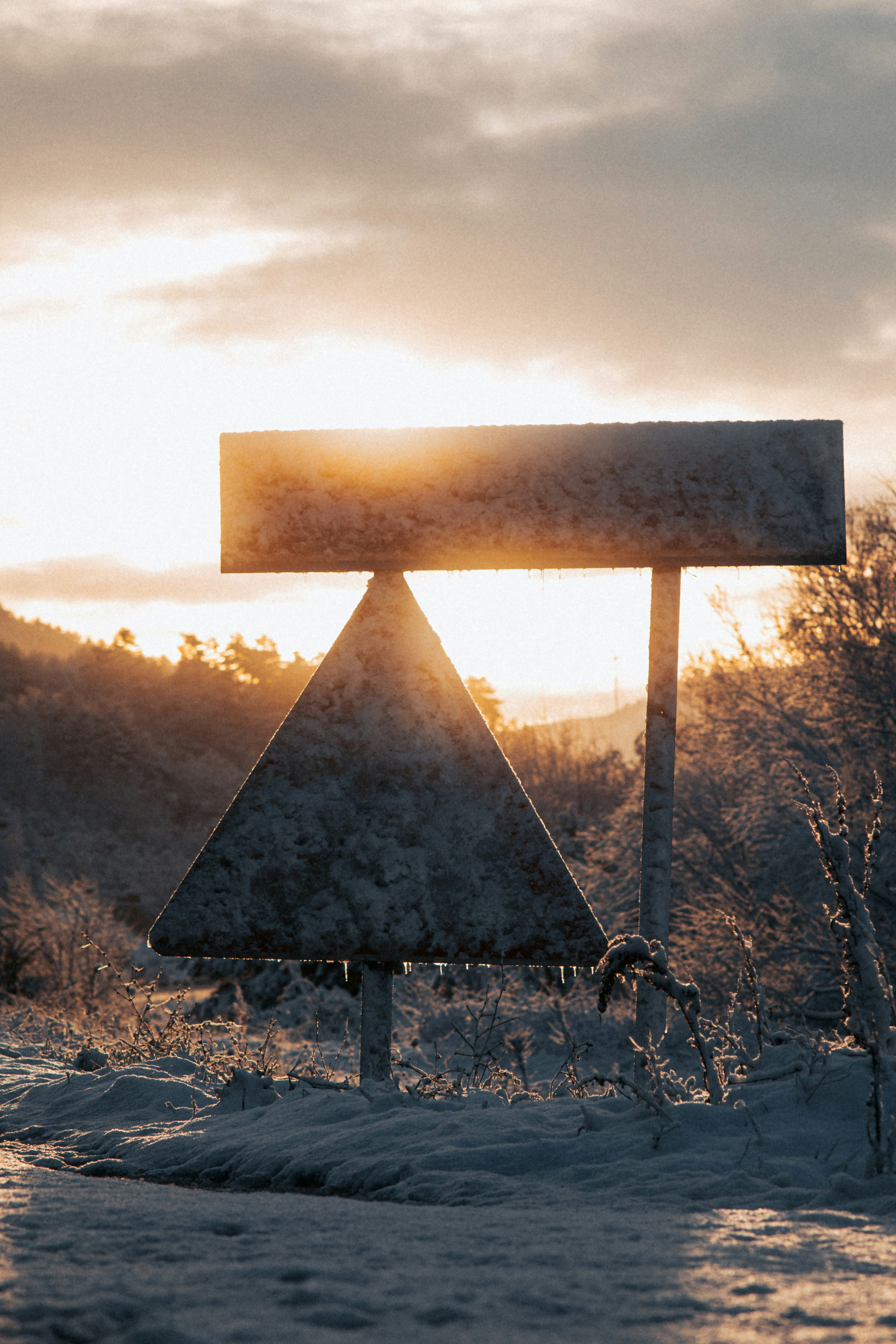 Sunset Through a Frosted Signpost: A Quiet Snowfield Scene