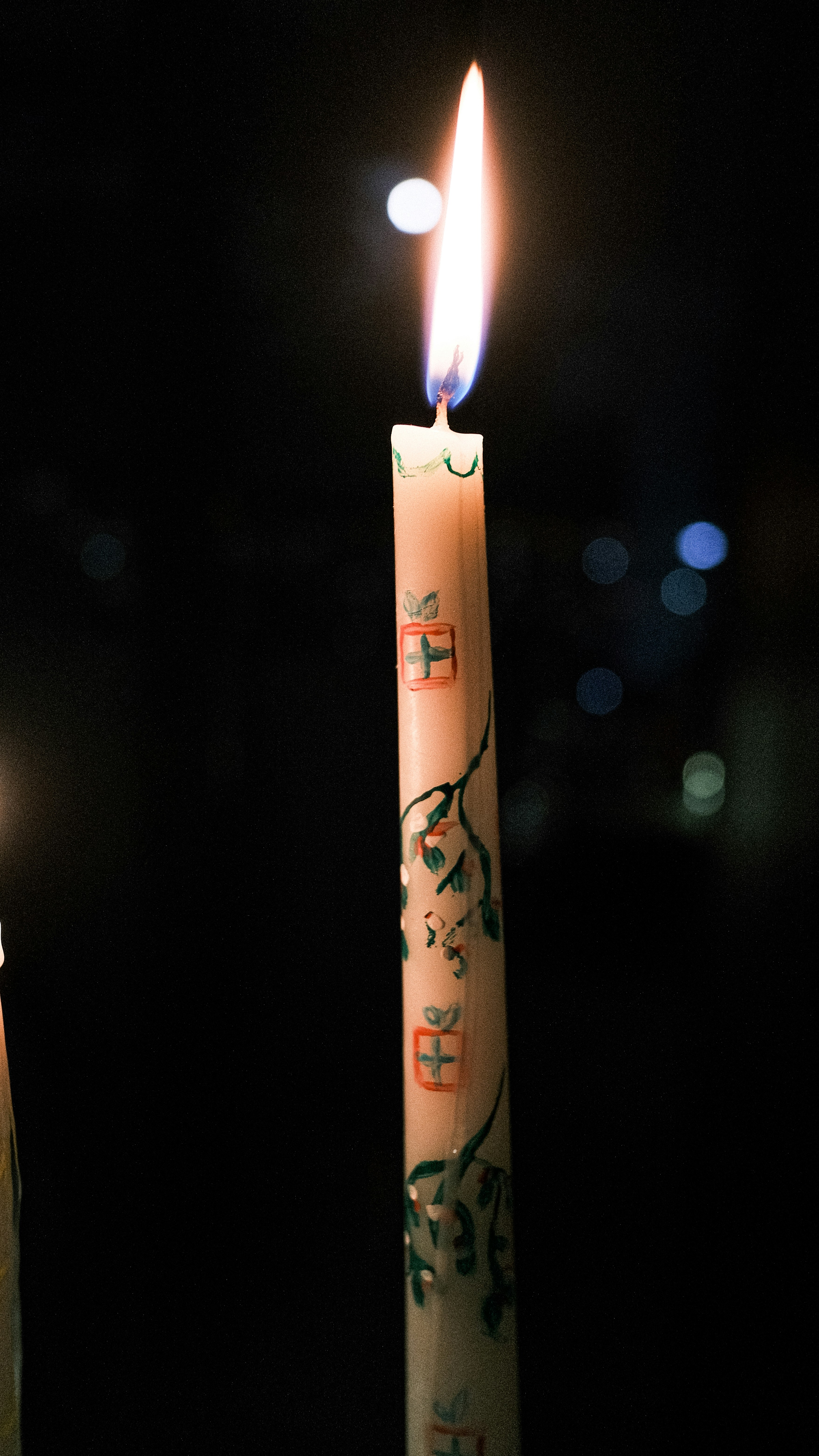 A Decorated Candle's Quiet Flame Against a Velvet Night