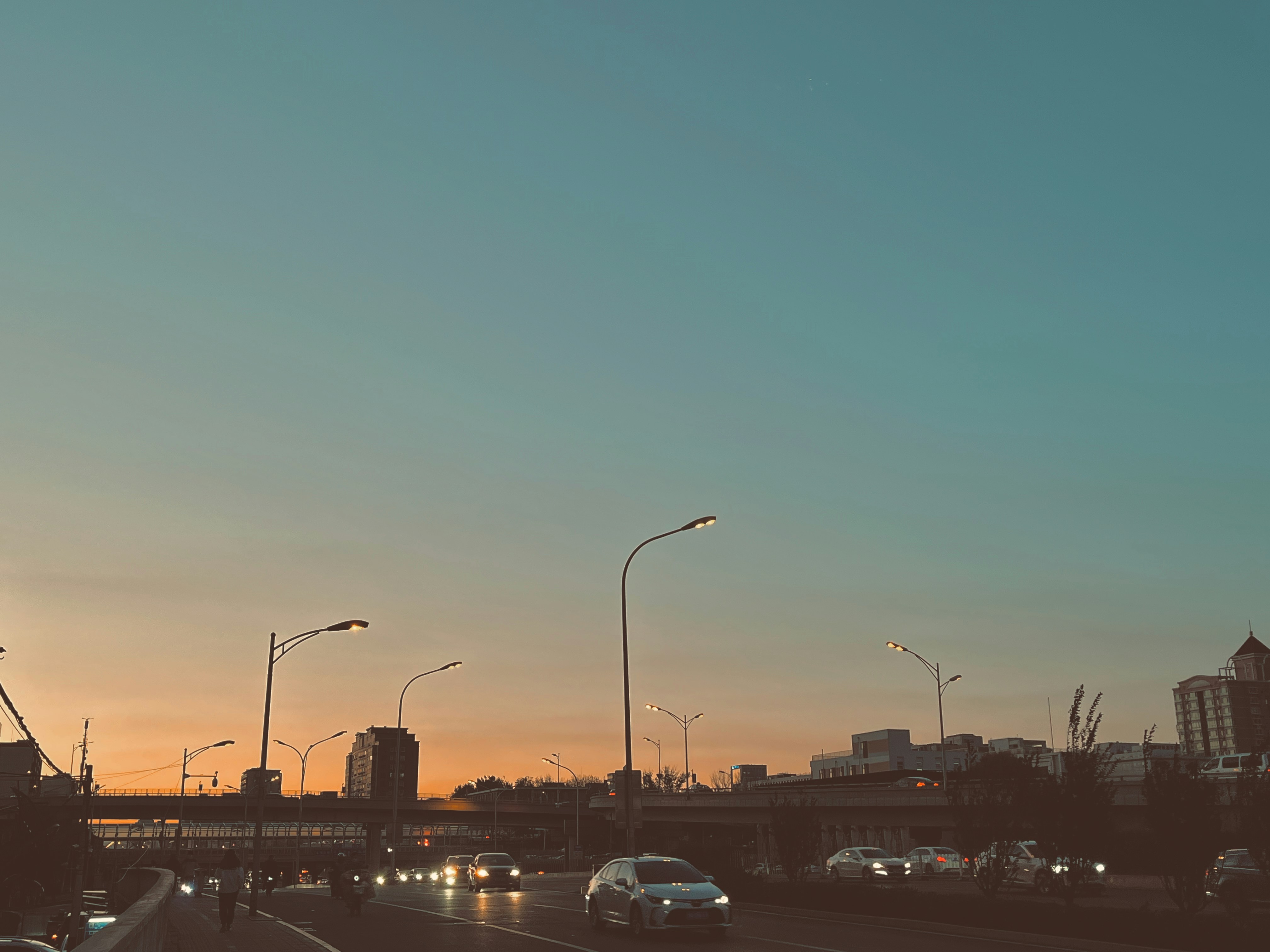 a street filled with lots of traffic next to tall buildings
