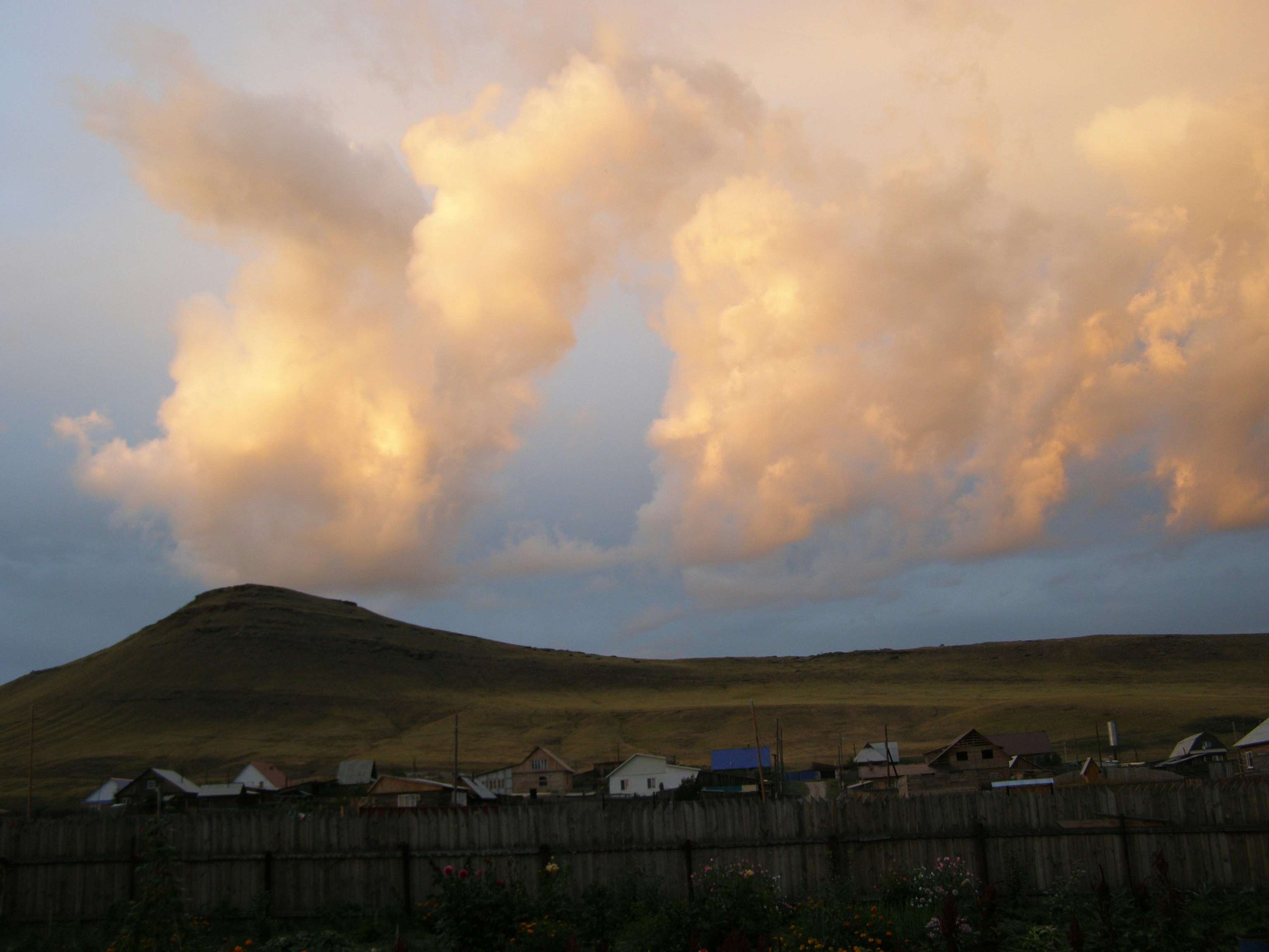 Sunlit Cumuli Over a Hushed Hillside Village