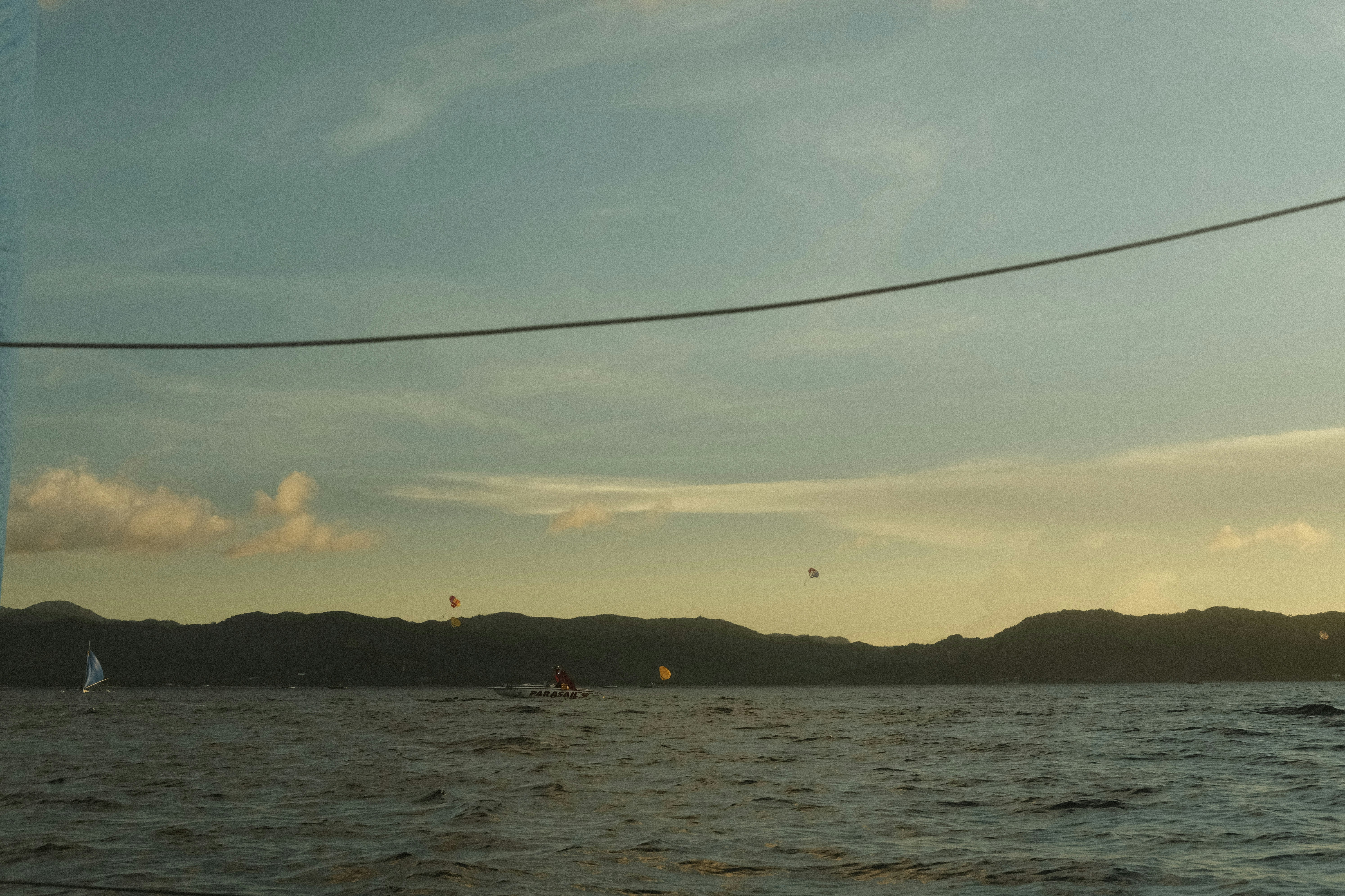 Dusk Winds Over the Horizon: Distant Kites Skimming the Quiet Sea