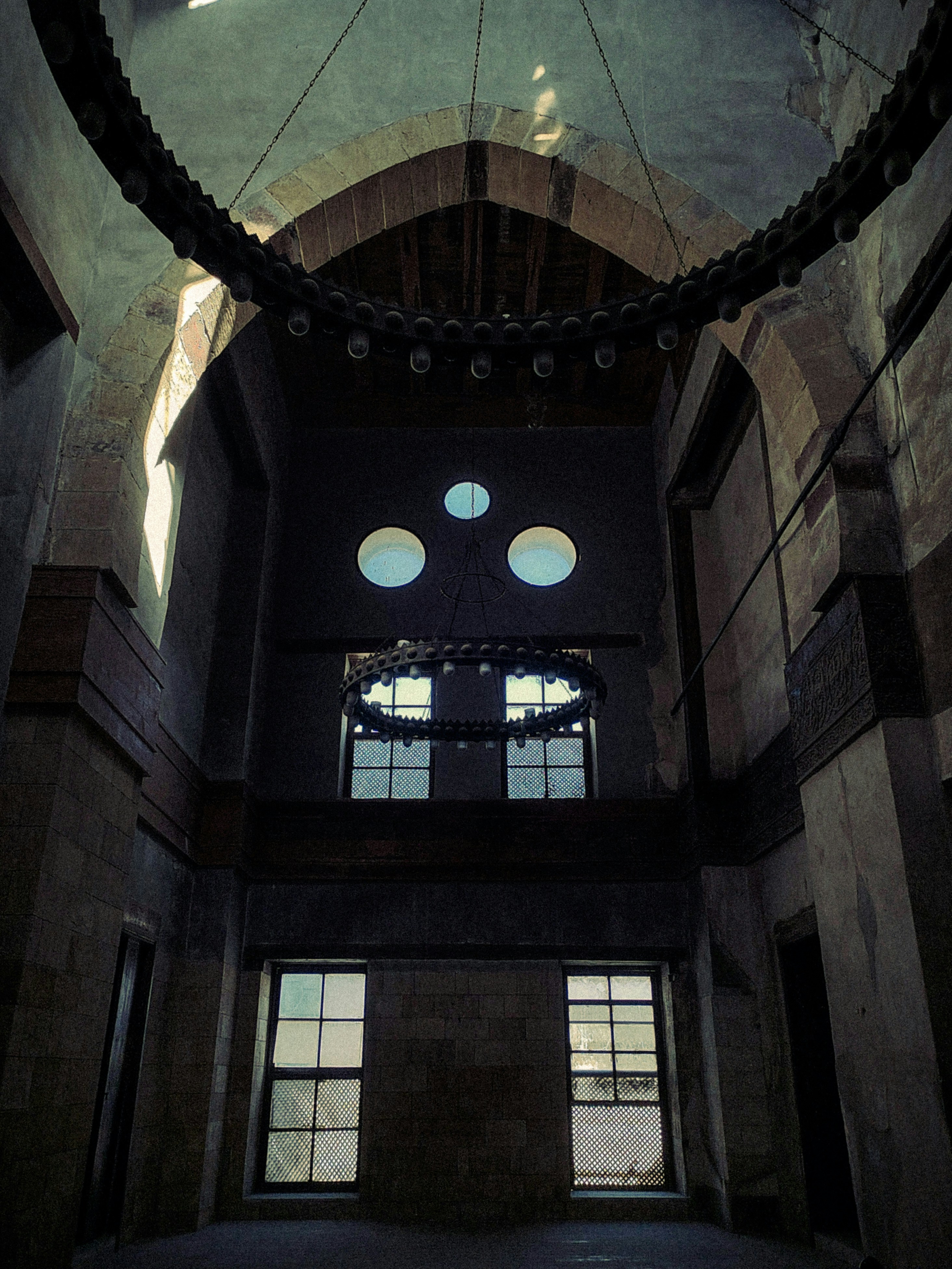 Three Circular Windows Over a Dim Gothic Atrium: Quiet Light in an Old Cathedral