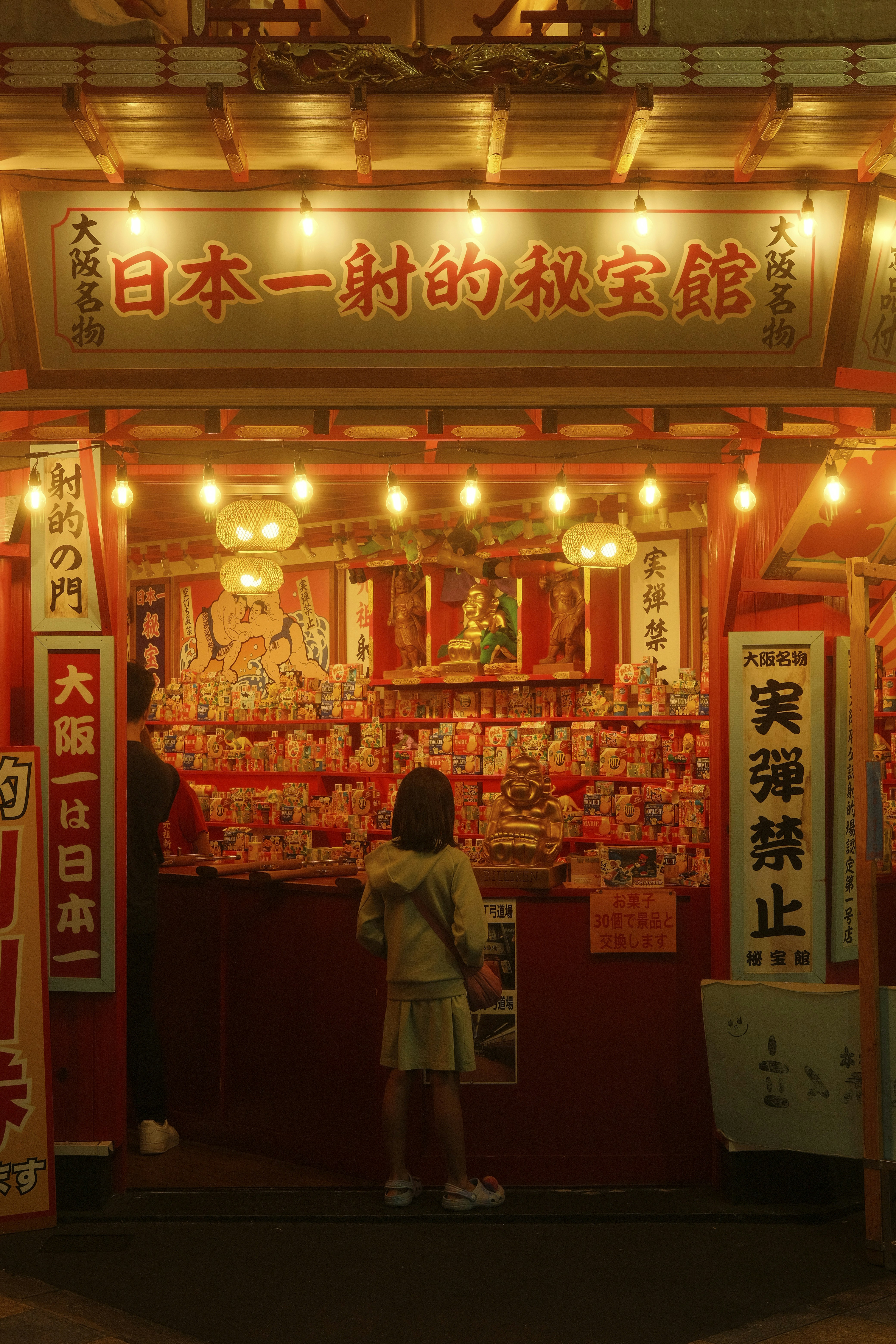 Lantern-lit Shrine Shop: A Girl Gathers Curiosity Amid Colorful Stalls