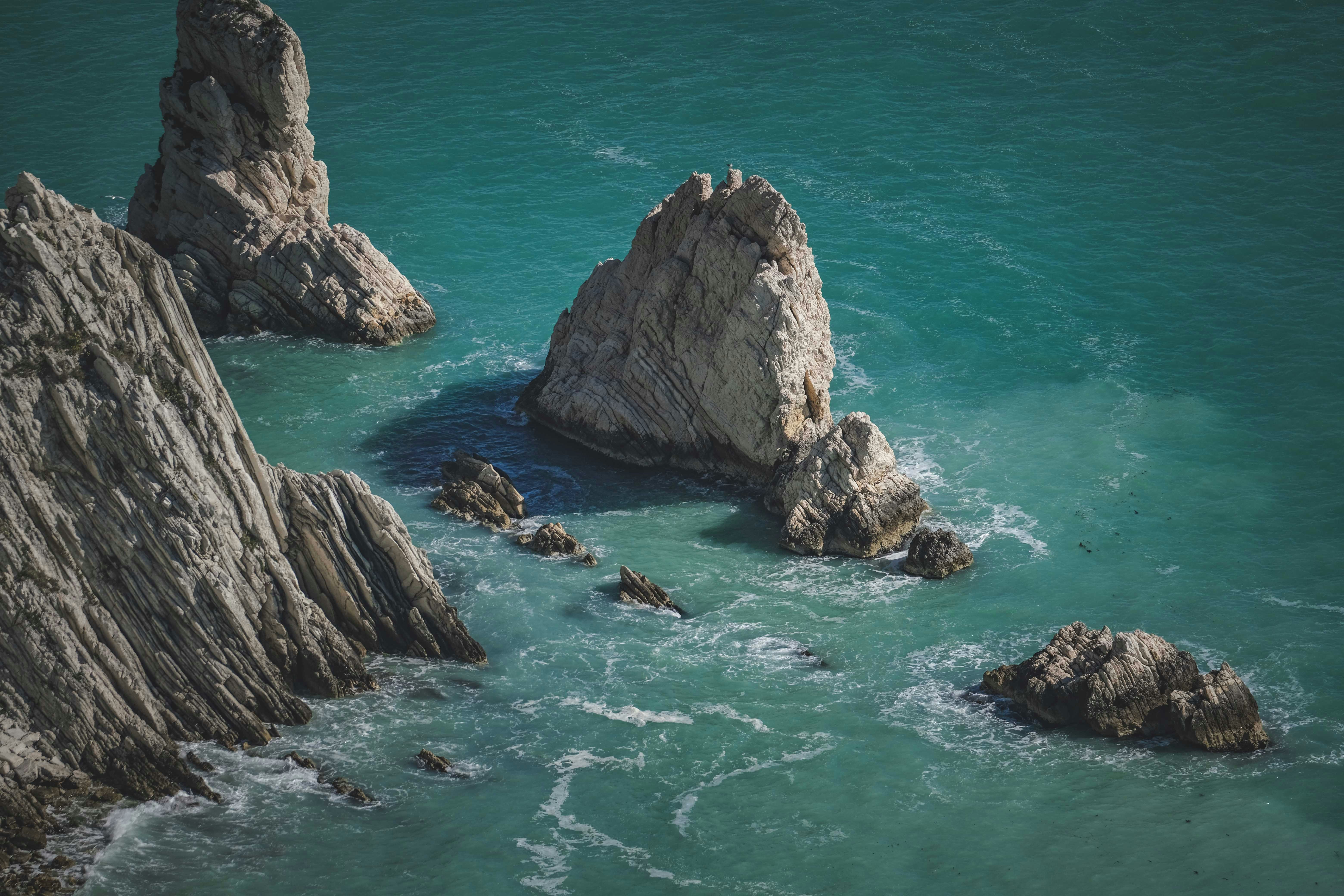 An aerial view of the ocean with rocks in the water photo – Free Nature ...
