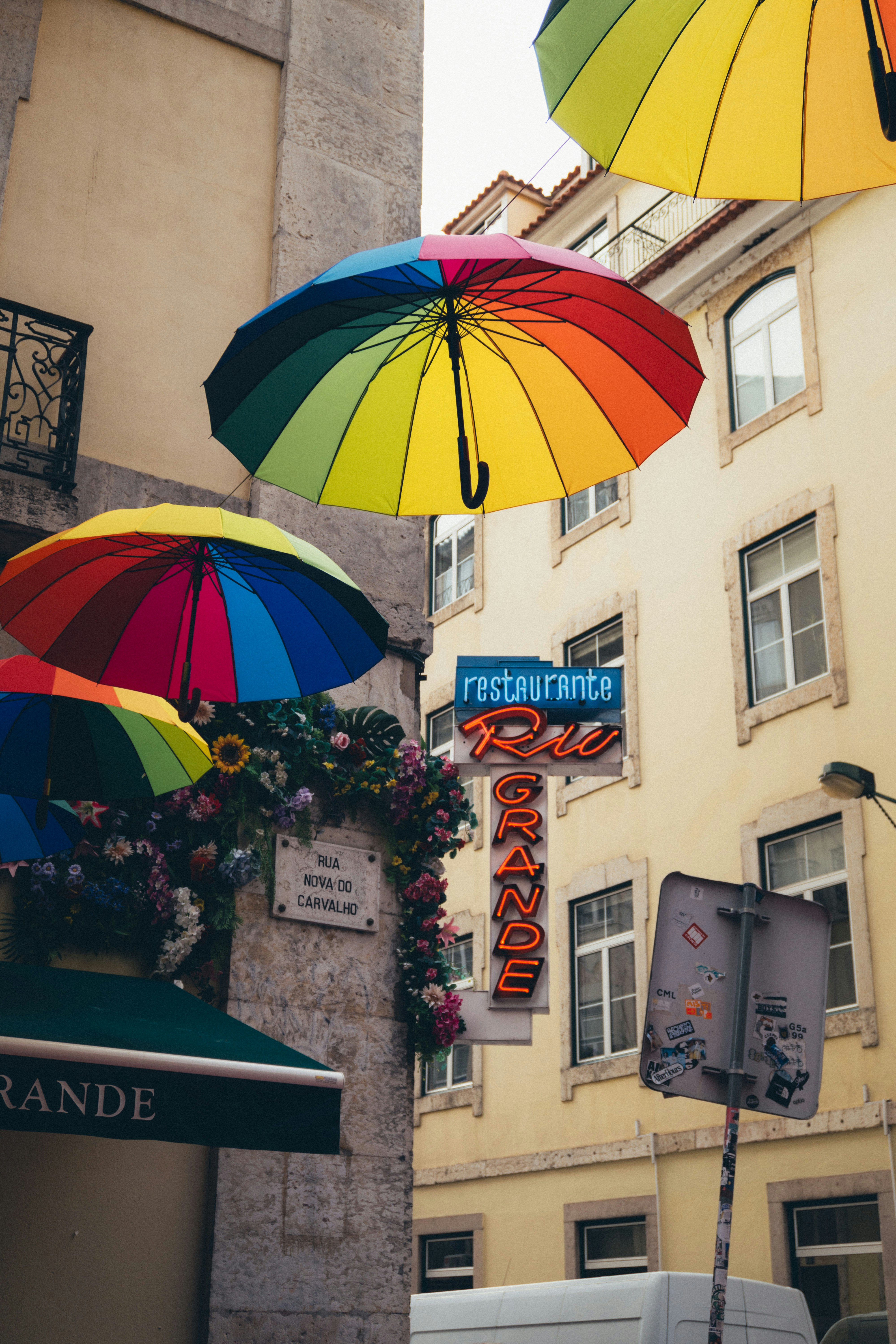 A group of colorful umbrellas hanging from the side of a building photo ...