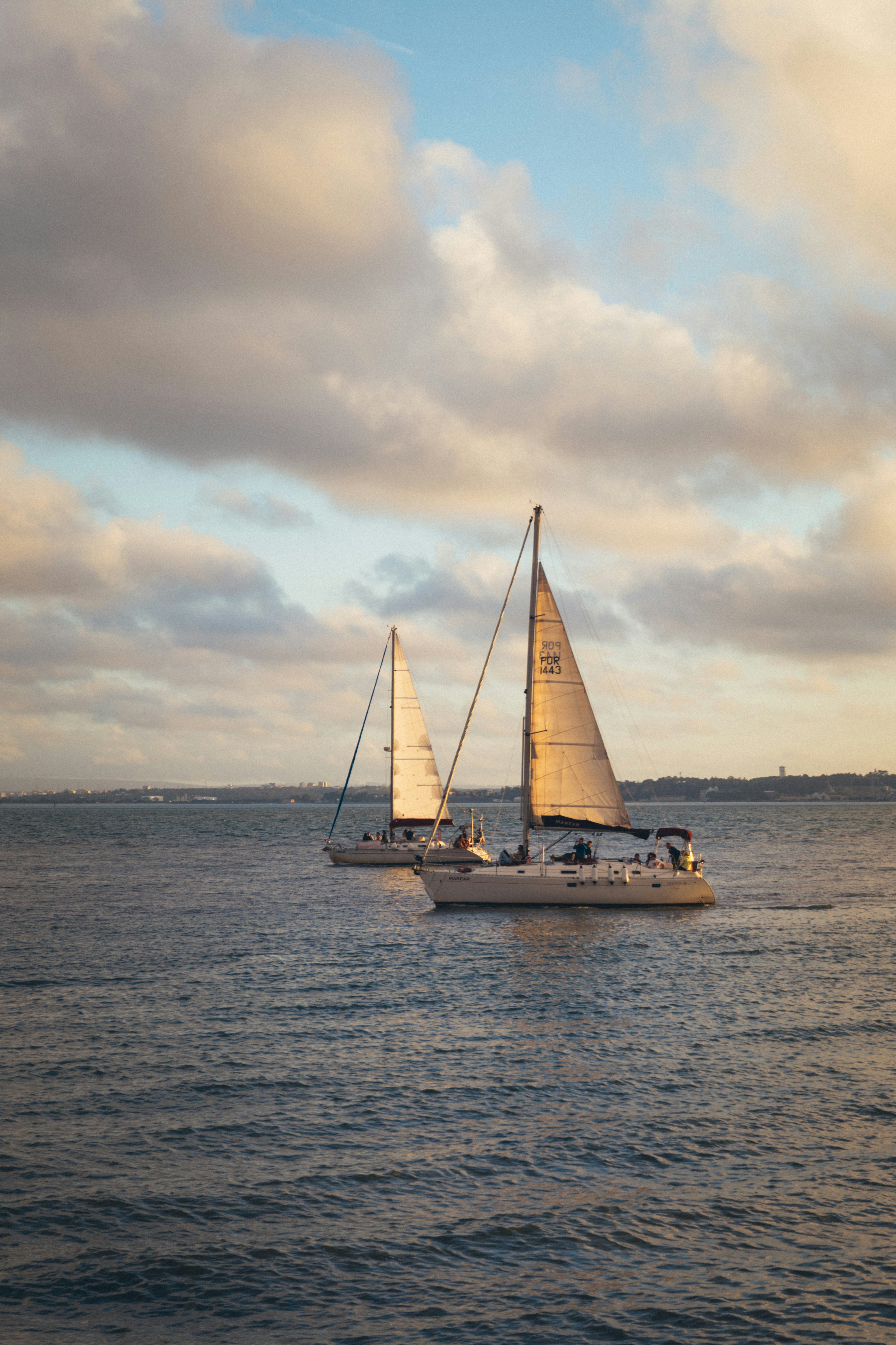 A sailboat sailing on the ocean under a cloudy sky photo – Free Sea ...