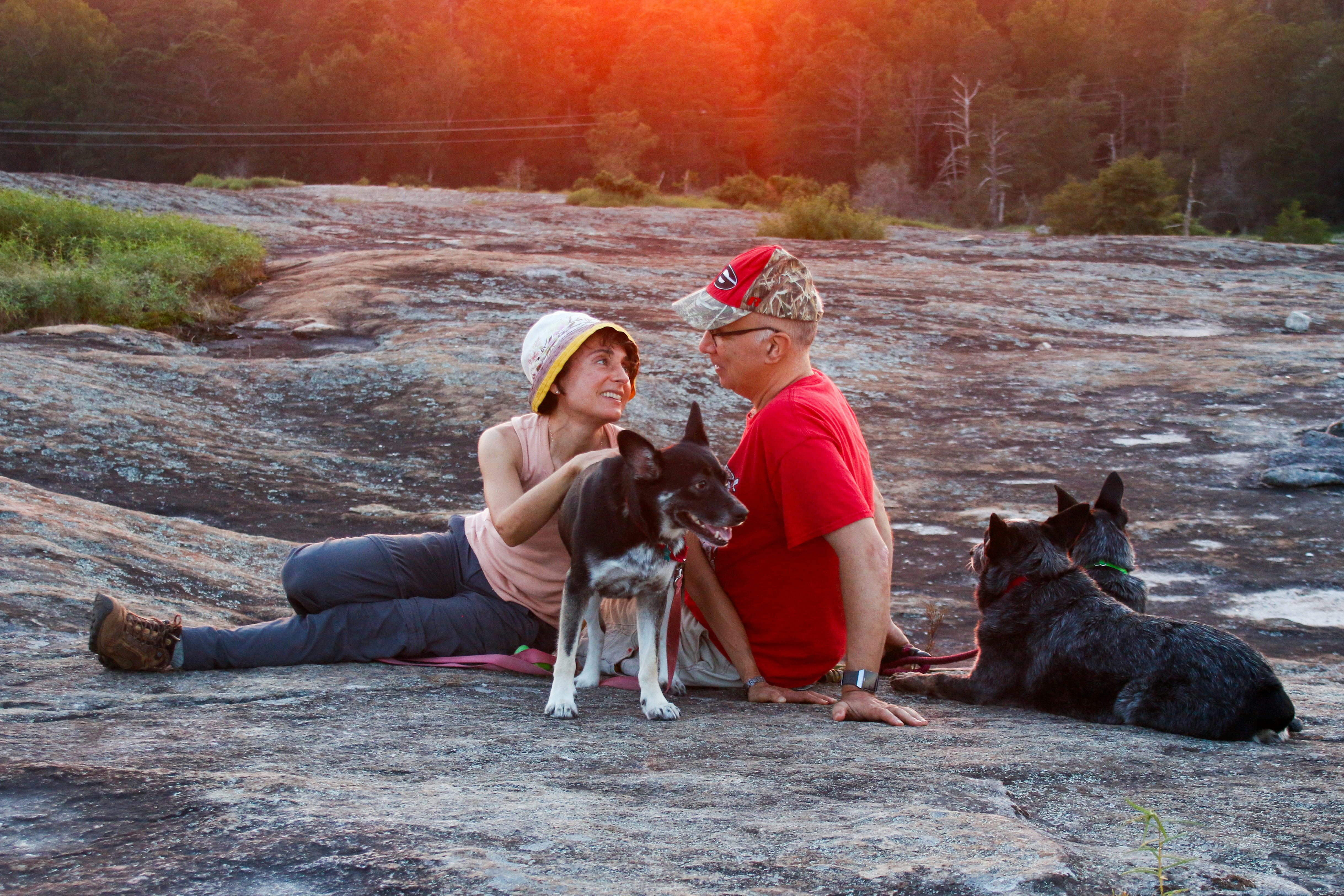 Sunset on Granite: a couple and their dogs share a quiet moment on sun-warmed rock