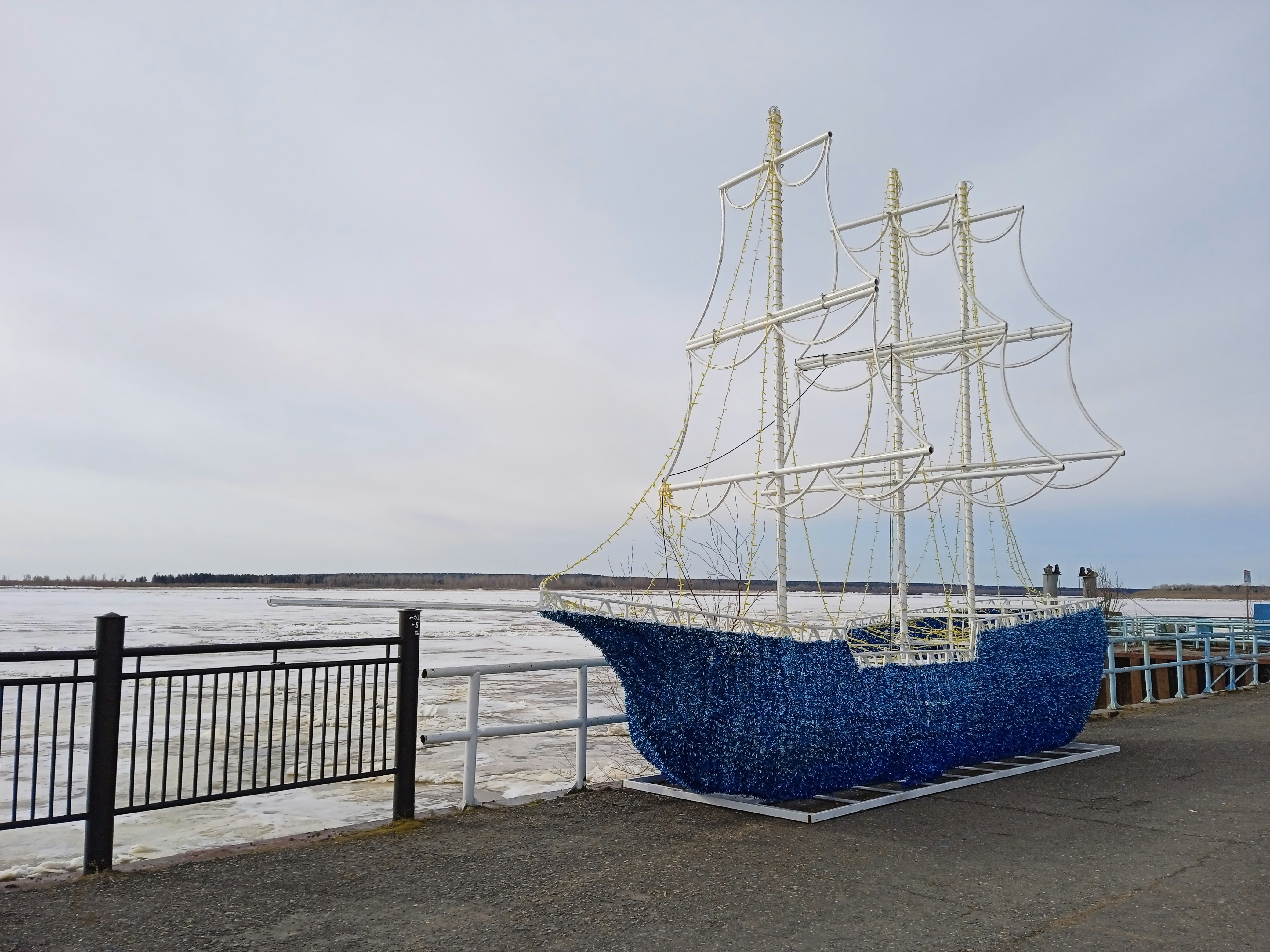 Icebound Vessel: A Mosaic Sailboat of Glassy Blue on a Quiet Seafront