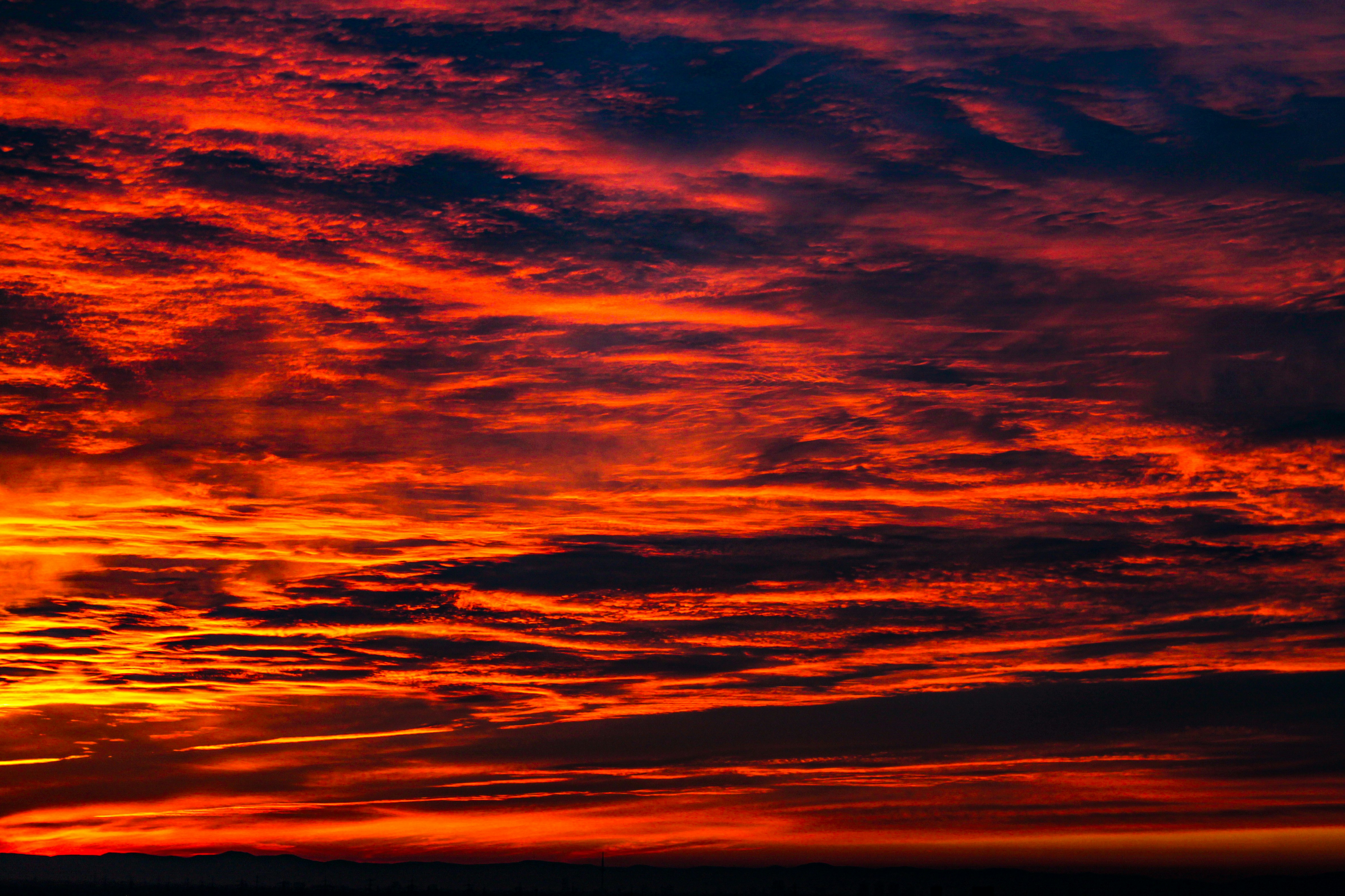A breathtaking sky ablaze with vivid red and orange hues, the clouds creating a dramatic pattern across the horizon at sunrise or sunset.Bernd 📷 Dittrich