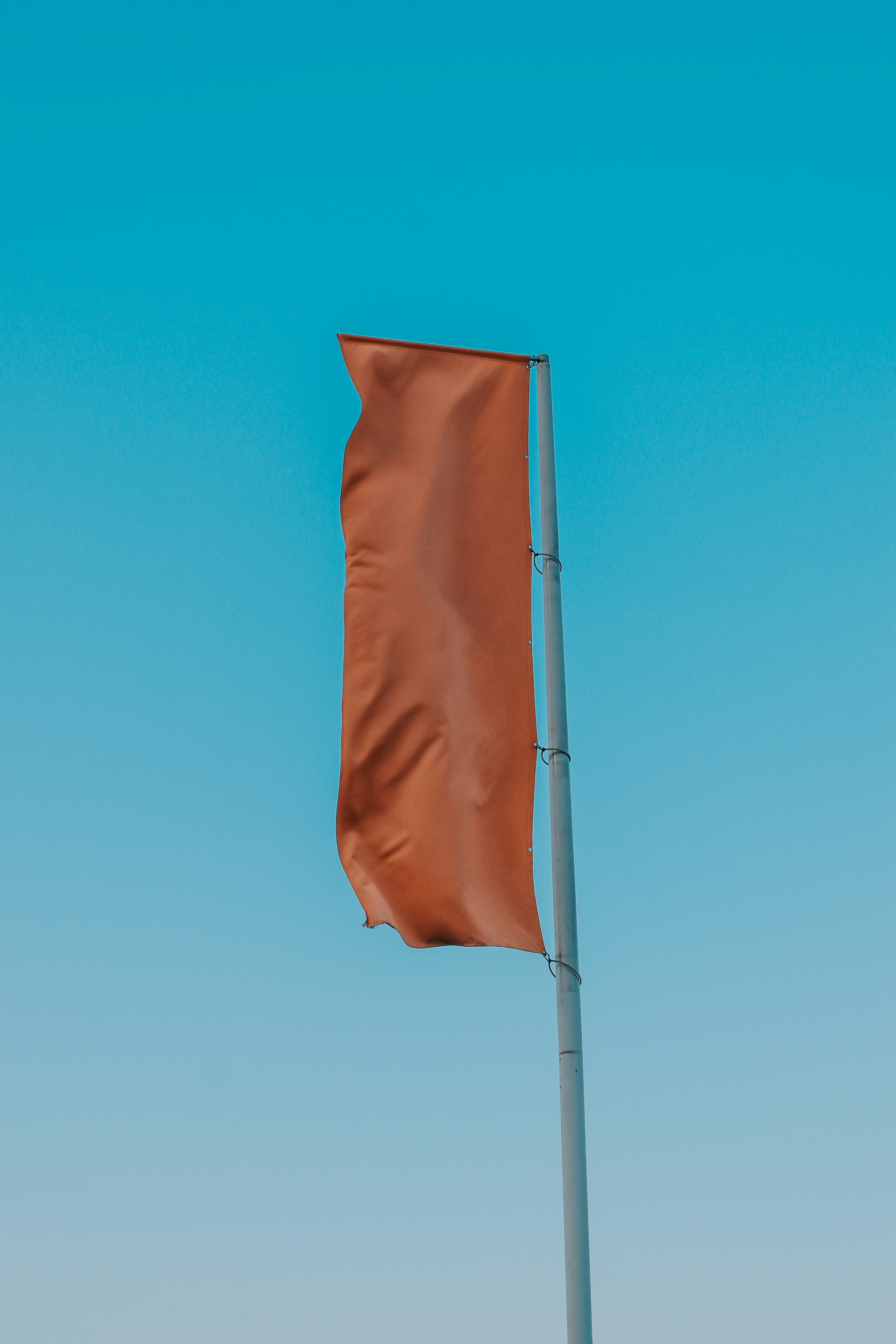 A brown flag is flying in the sky photo – Free Brown Image on Unsplash