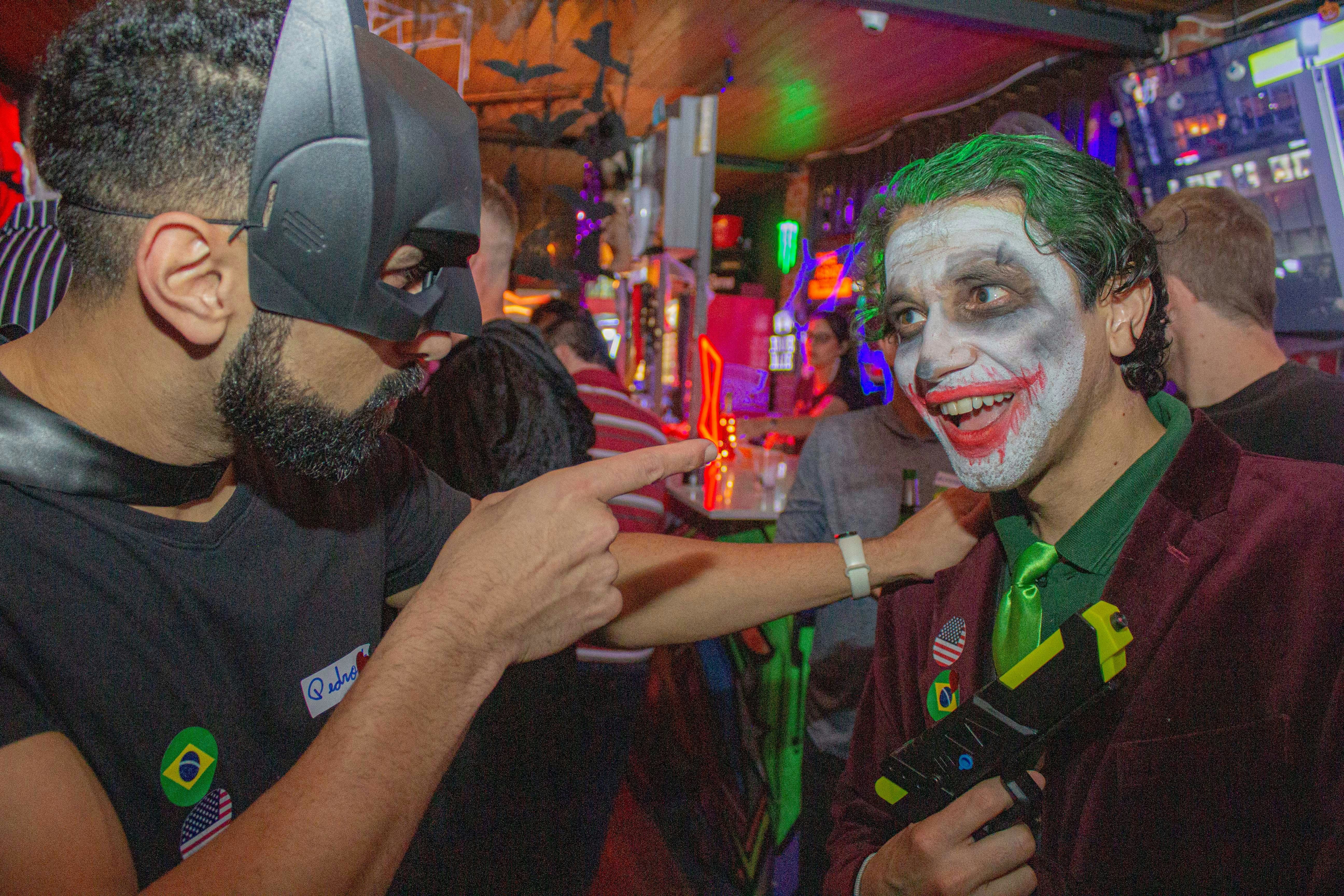 Two men dressed as batman and joker in a bar photo – Free Party Image ...