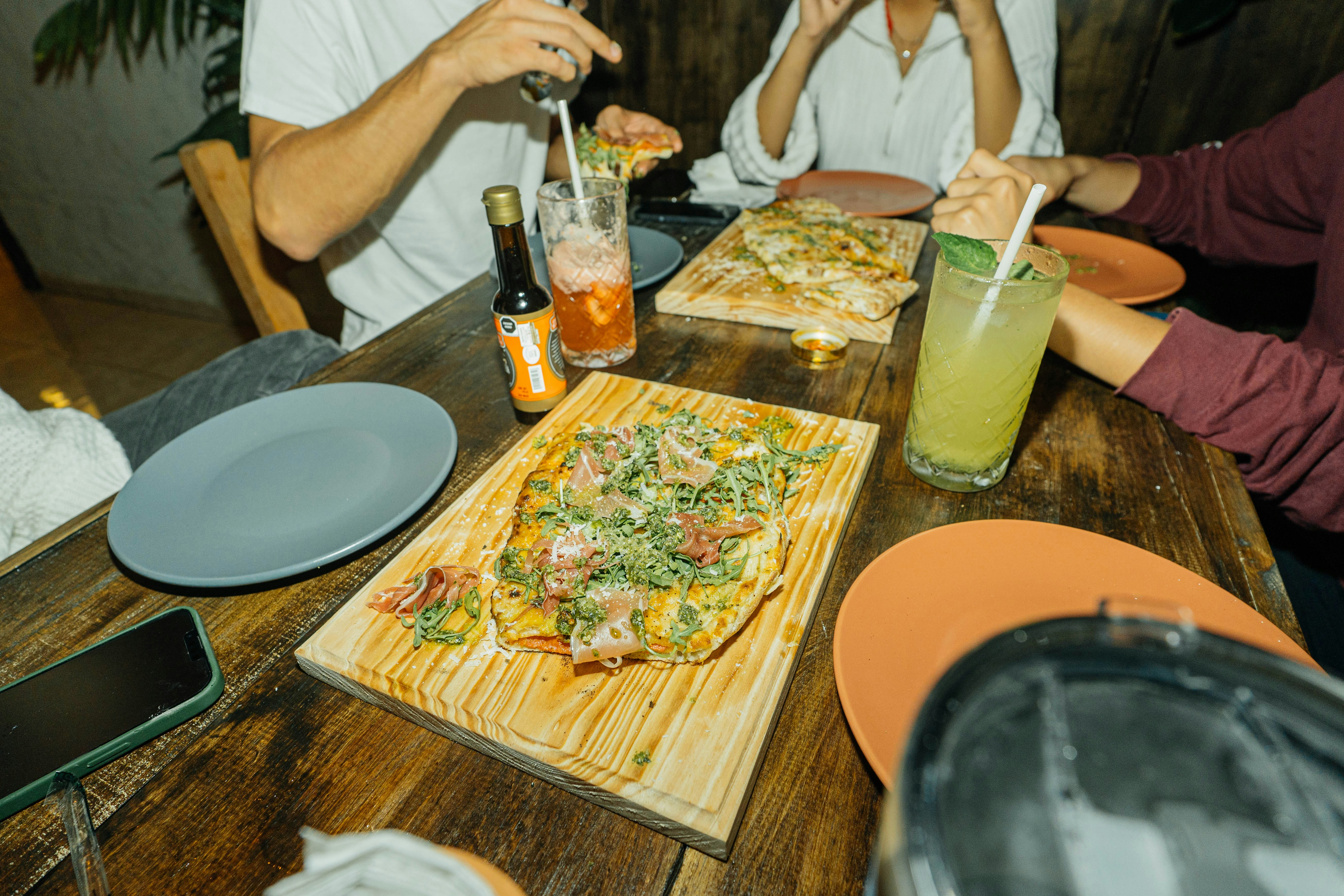 Centerboard Flatbread: Shared Pizza and Colorful Drinks at a Lively Table