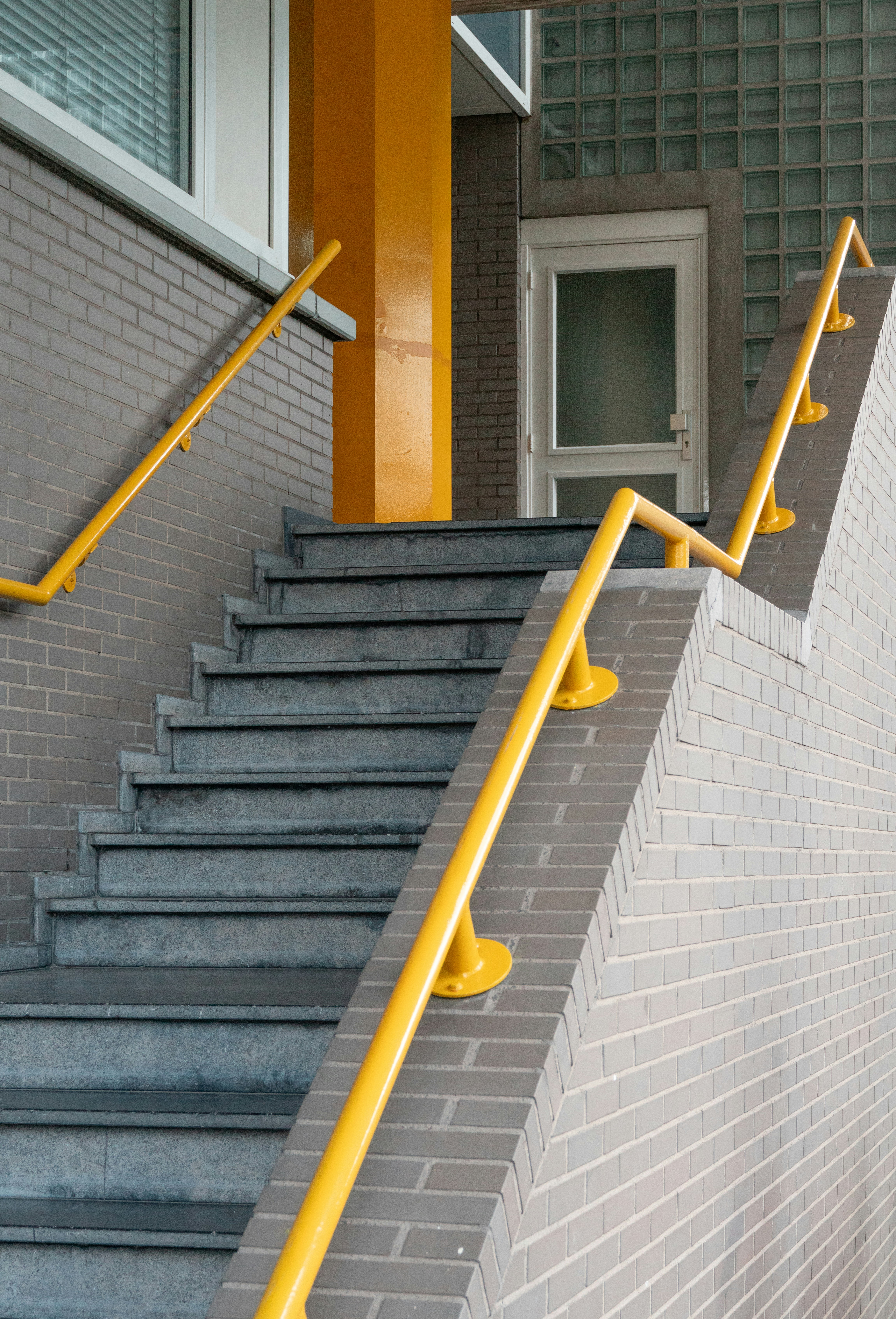 Angular Rhythm: Yellow Handrails Framing a City Staircase