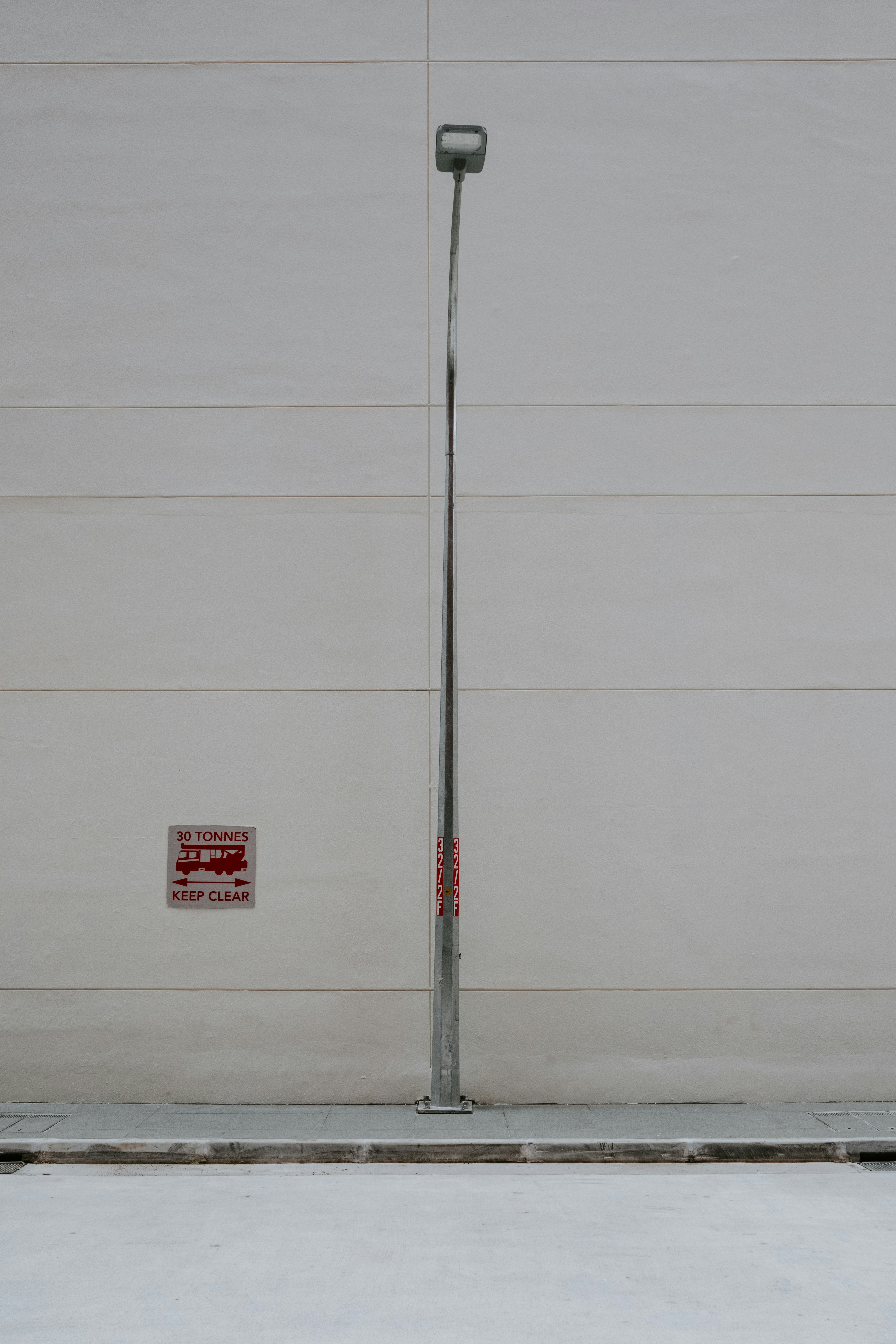 Centered streetlamp on a pale, panelled wall