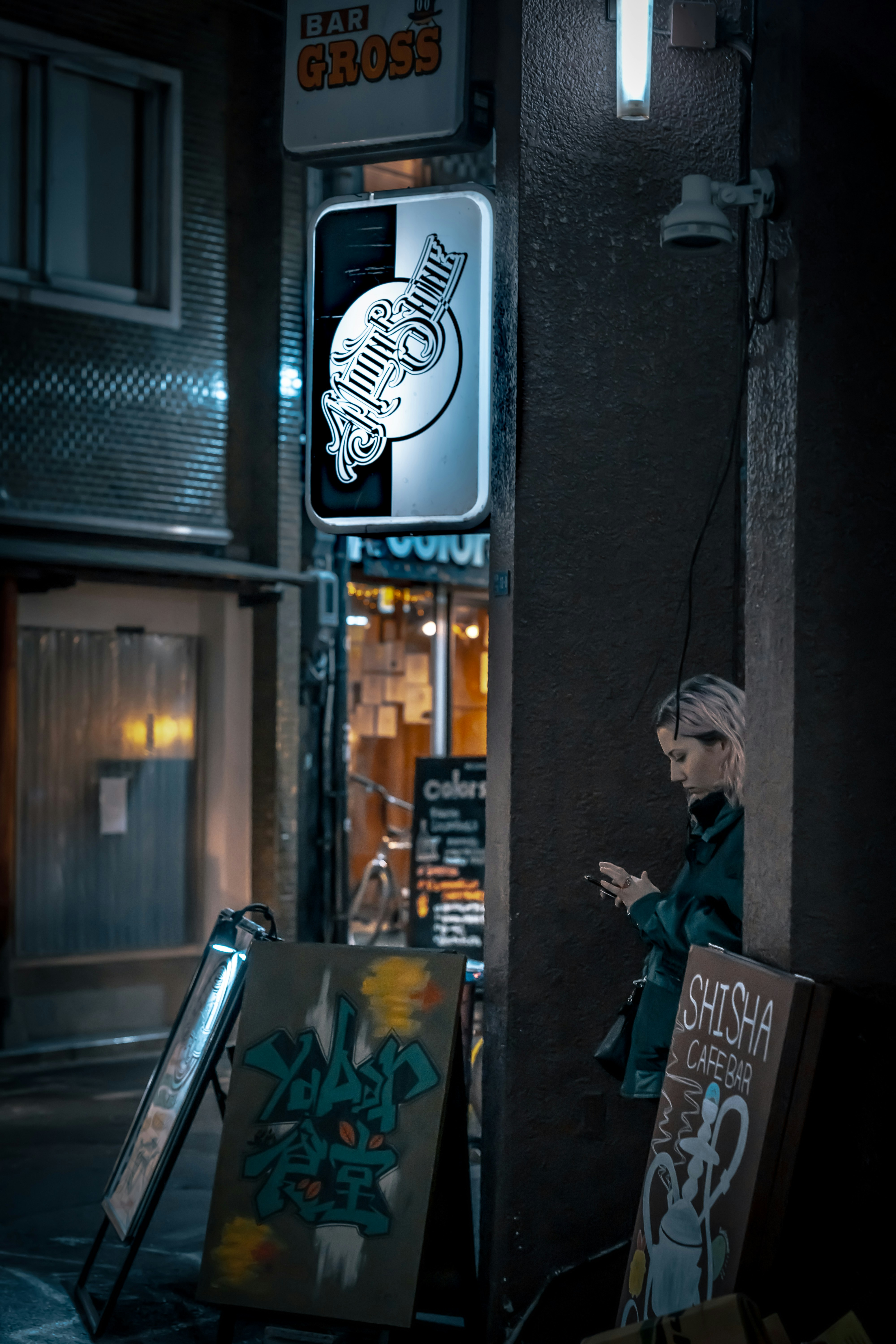 A woman standing next to a sign on the side of a building photo – Free ...