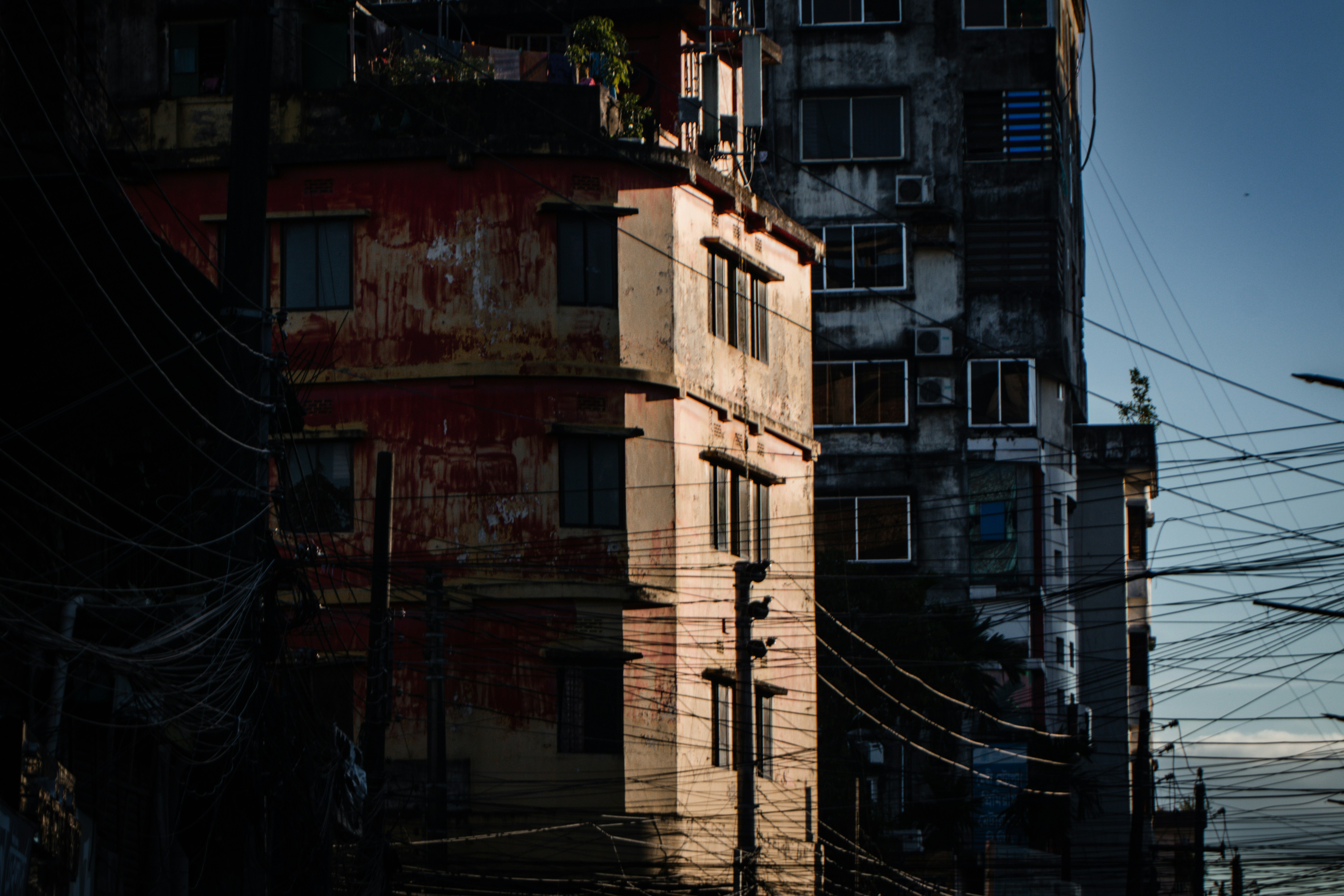 Sunlit Facade Amid Wires: A Quiet Urban Corner