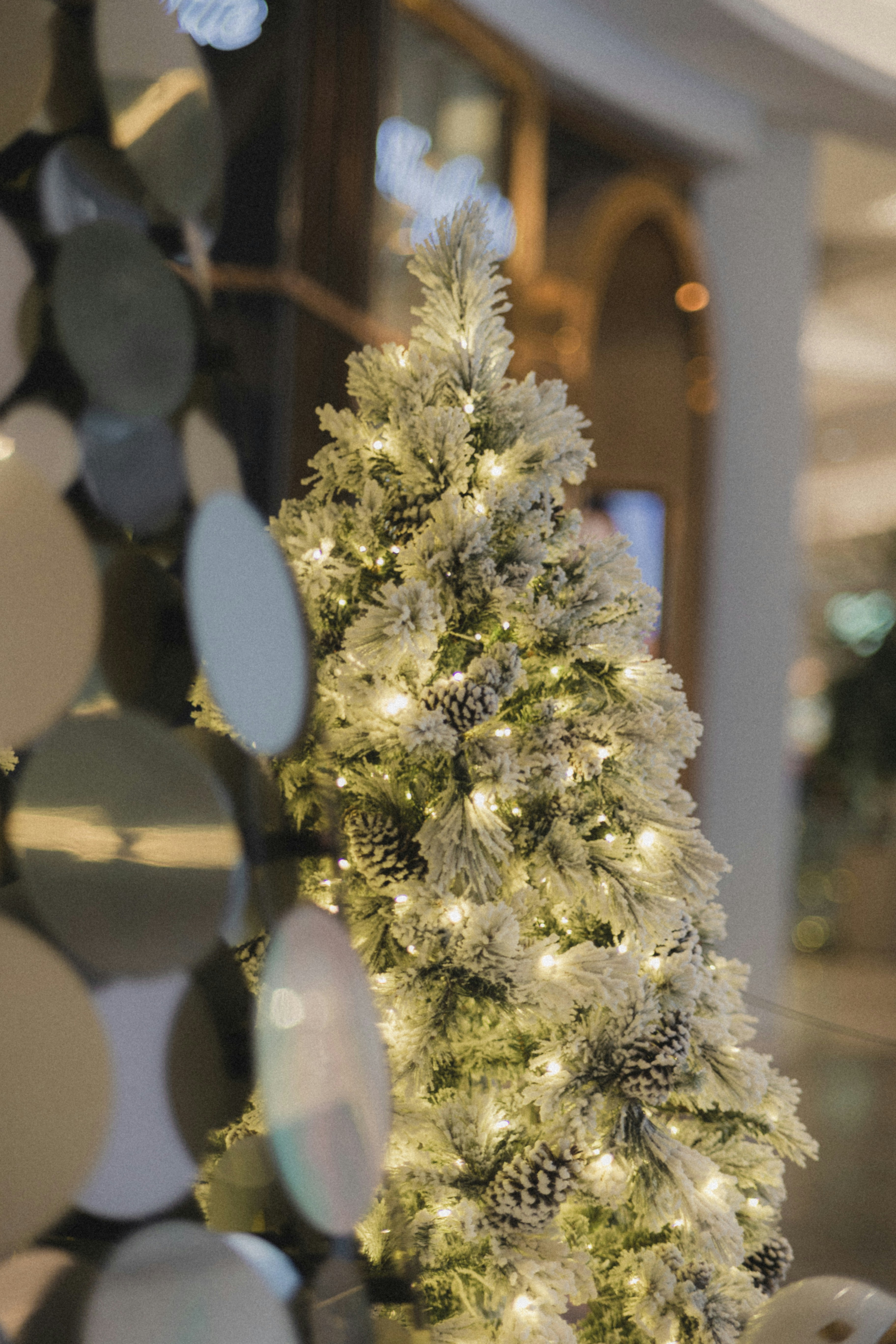 Snow-dusted Christmas Tree with Warm Fairy Lights in a Modern Lobby
