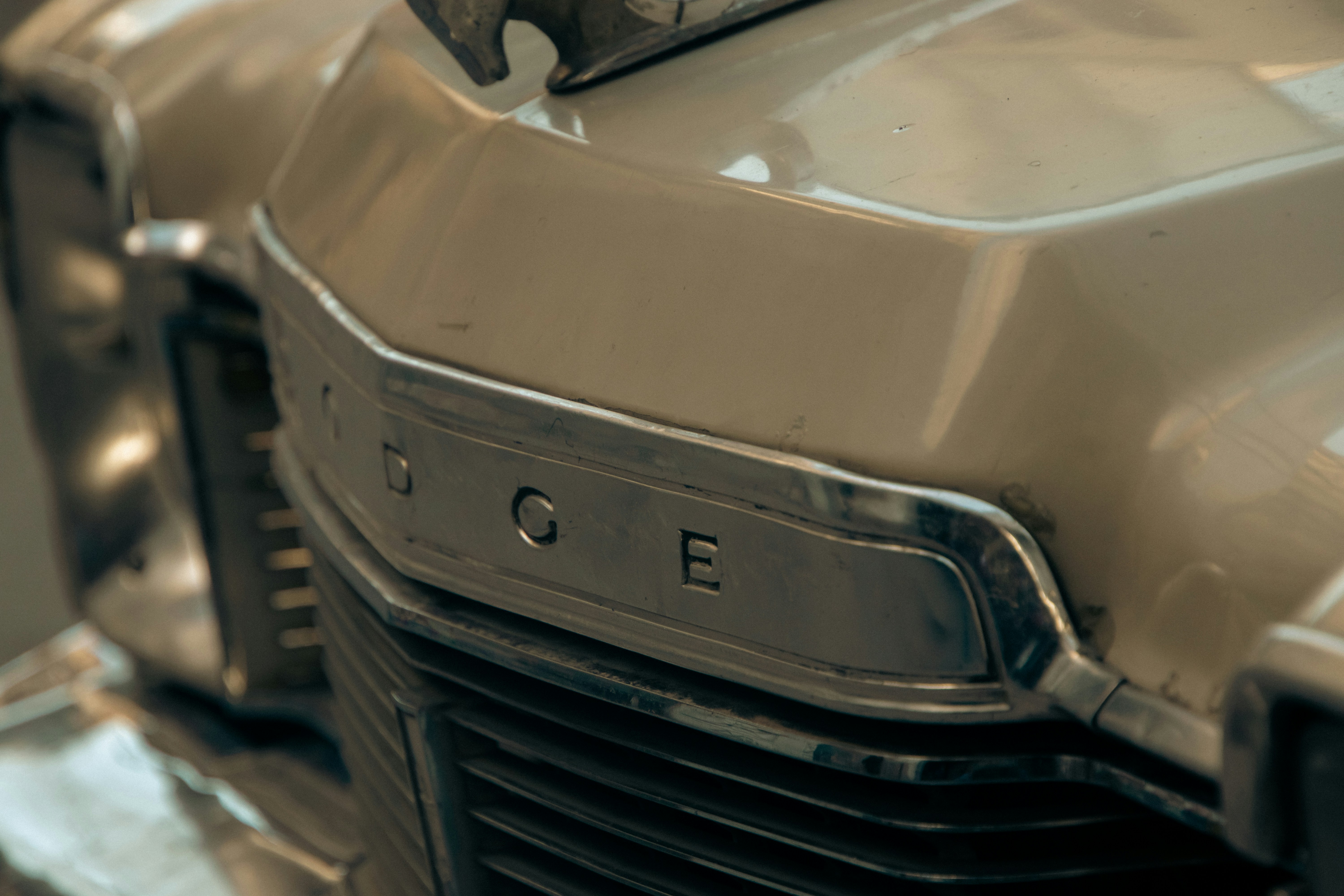 Weathered Chrome and Quiet Rust: Close-Up of a Vintage Car Front Emblem