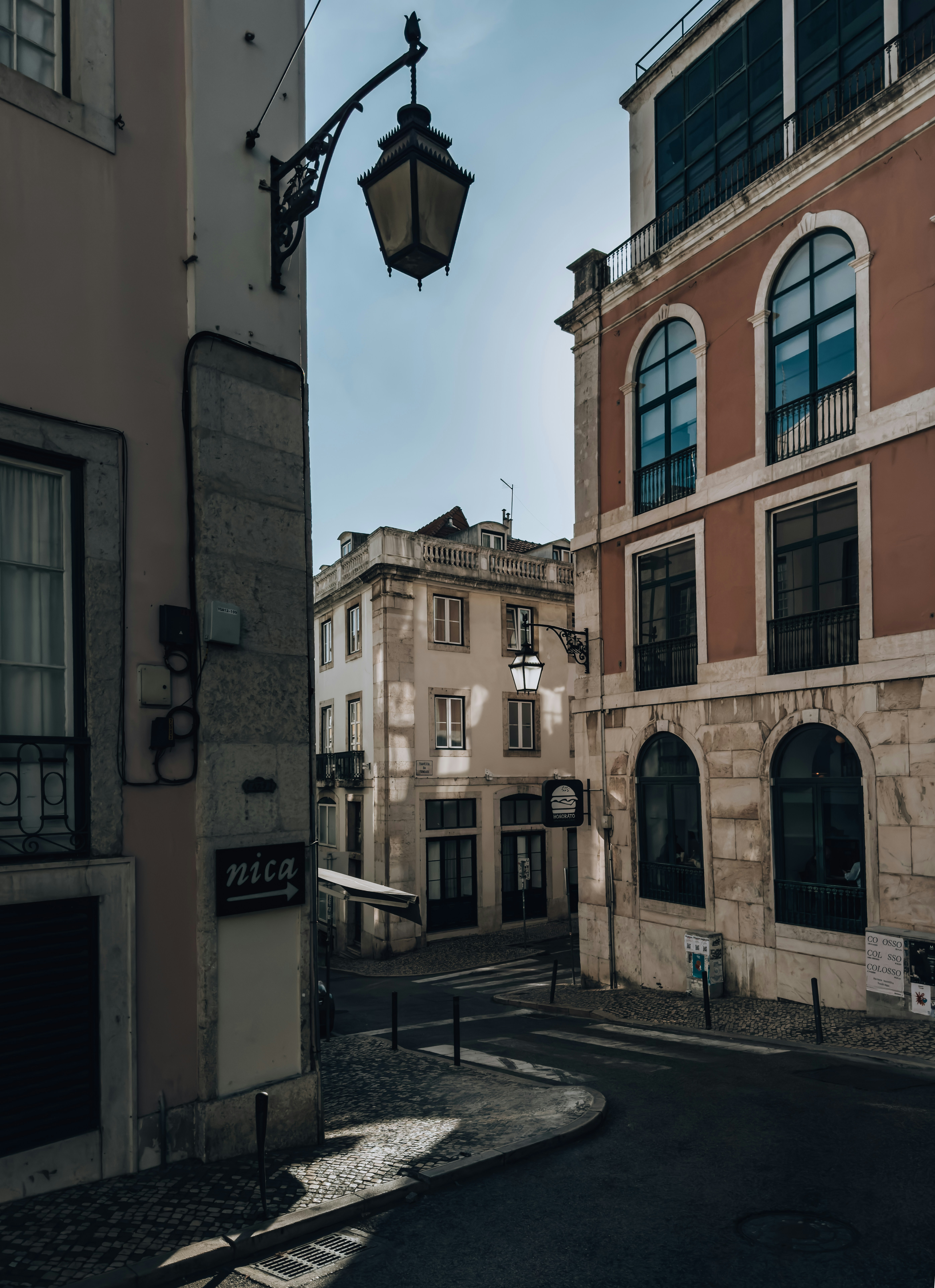Lantern Above the Narrow Alley: Sunlit Facades Framing a Quiet Passage
