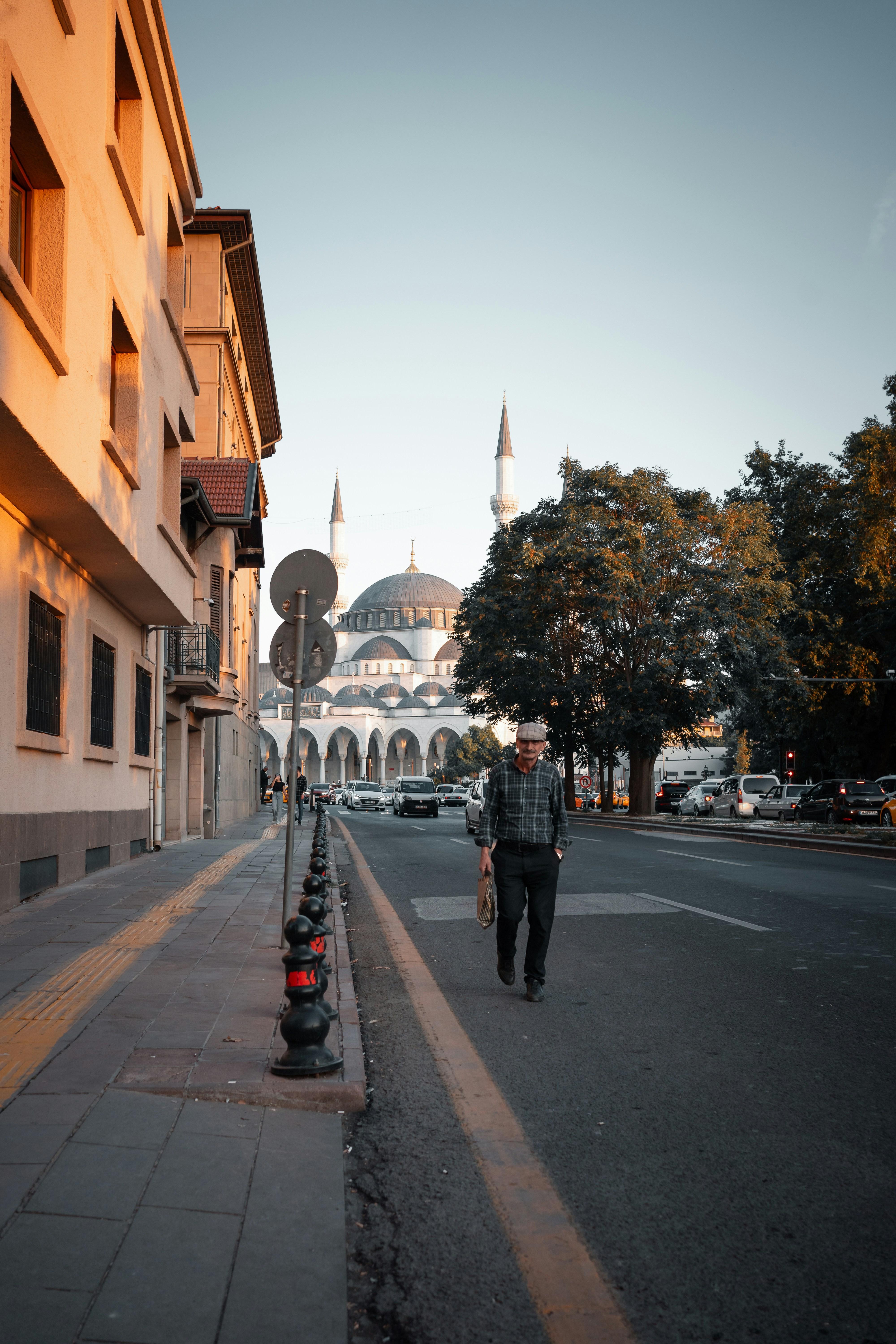 a man walking down a street next to a tall building