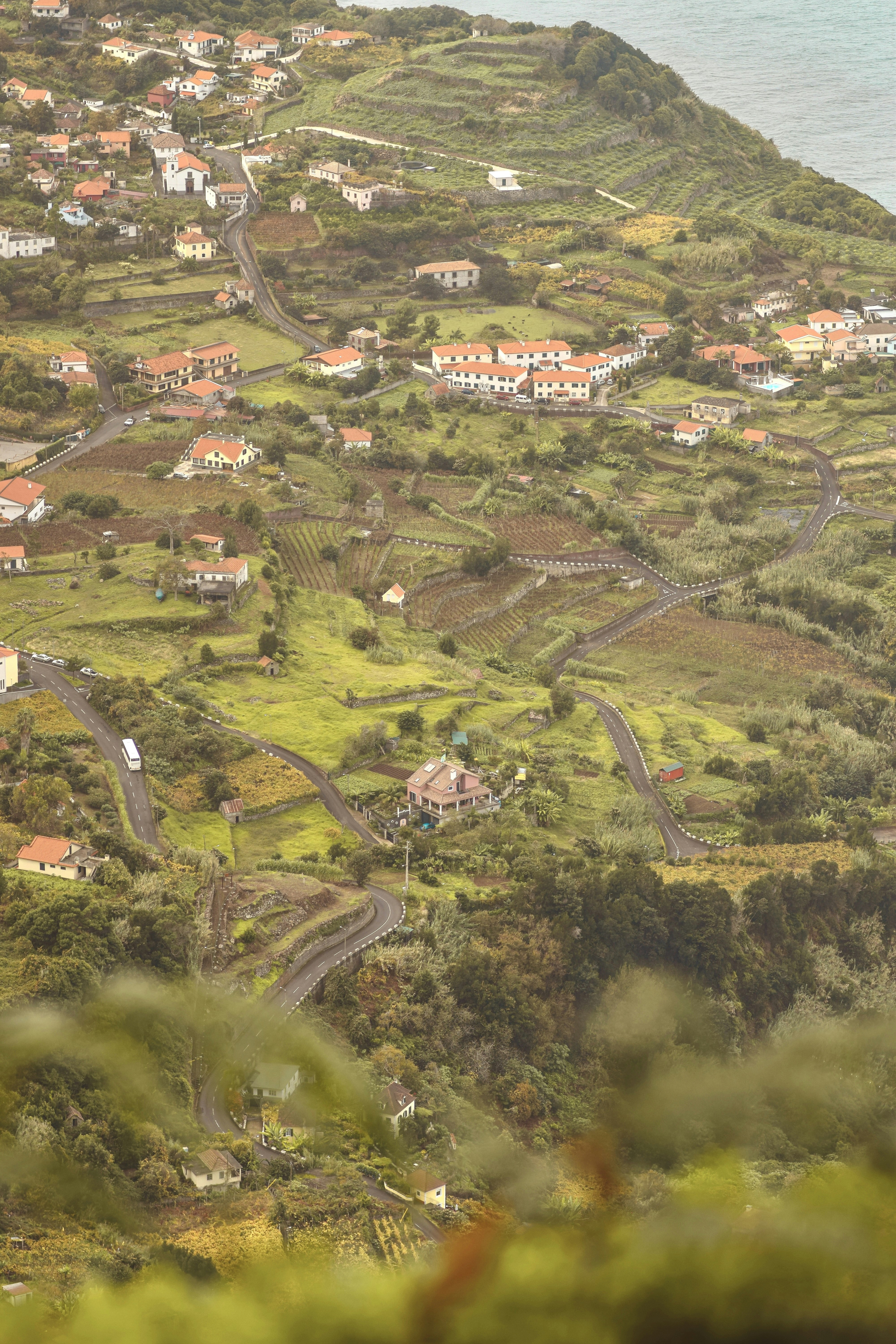 Terraced Ridge Village: Red-Roofed Homes Winding Along a Coastal Curve