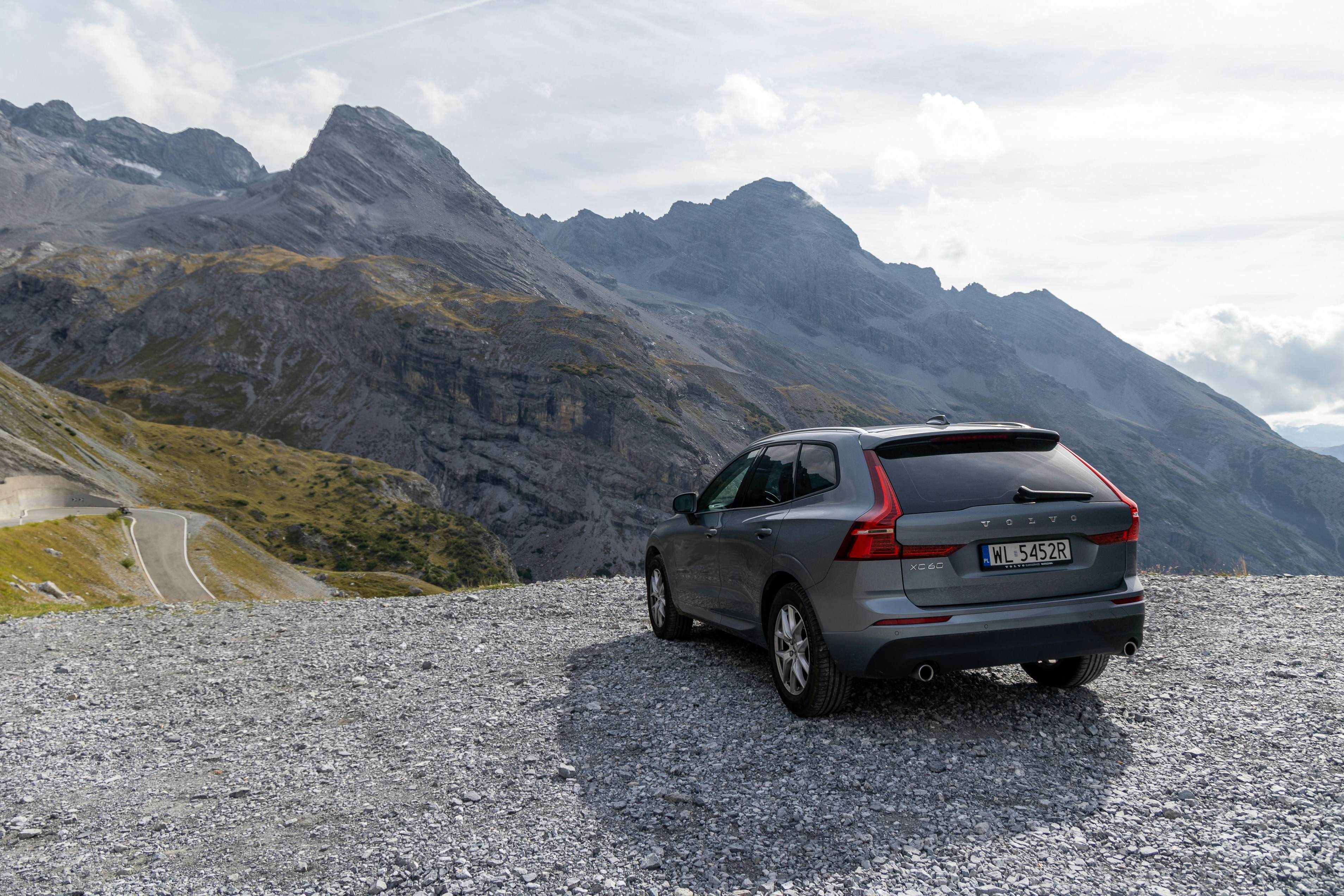 A car parked on a gravel road in the mountains photo – Free Passo dello ...