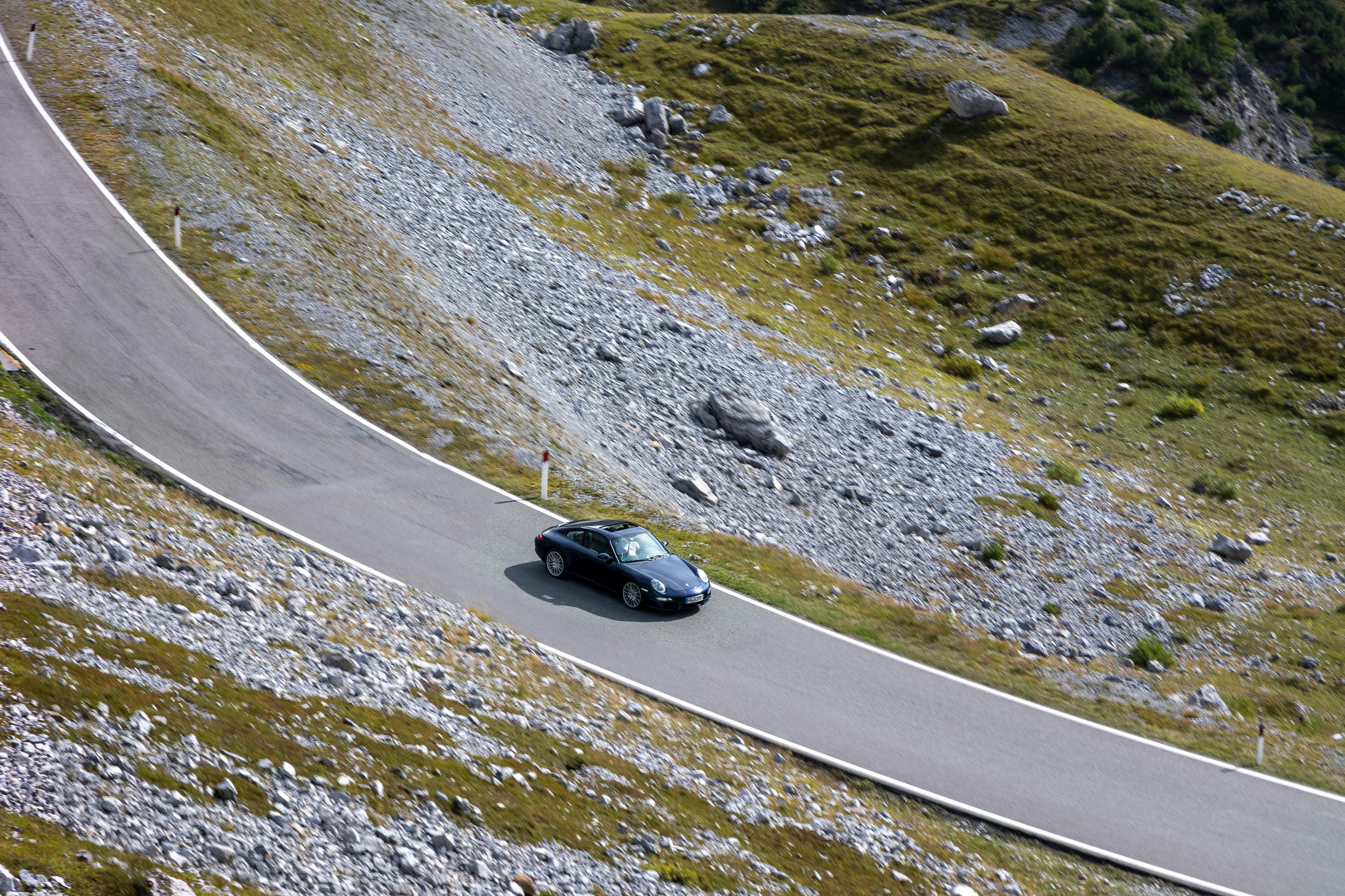 A car driving down a winding mountain road photo – Free Passo dello ...