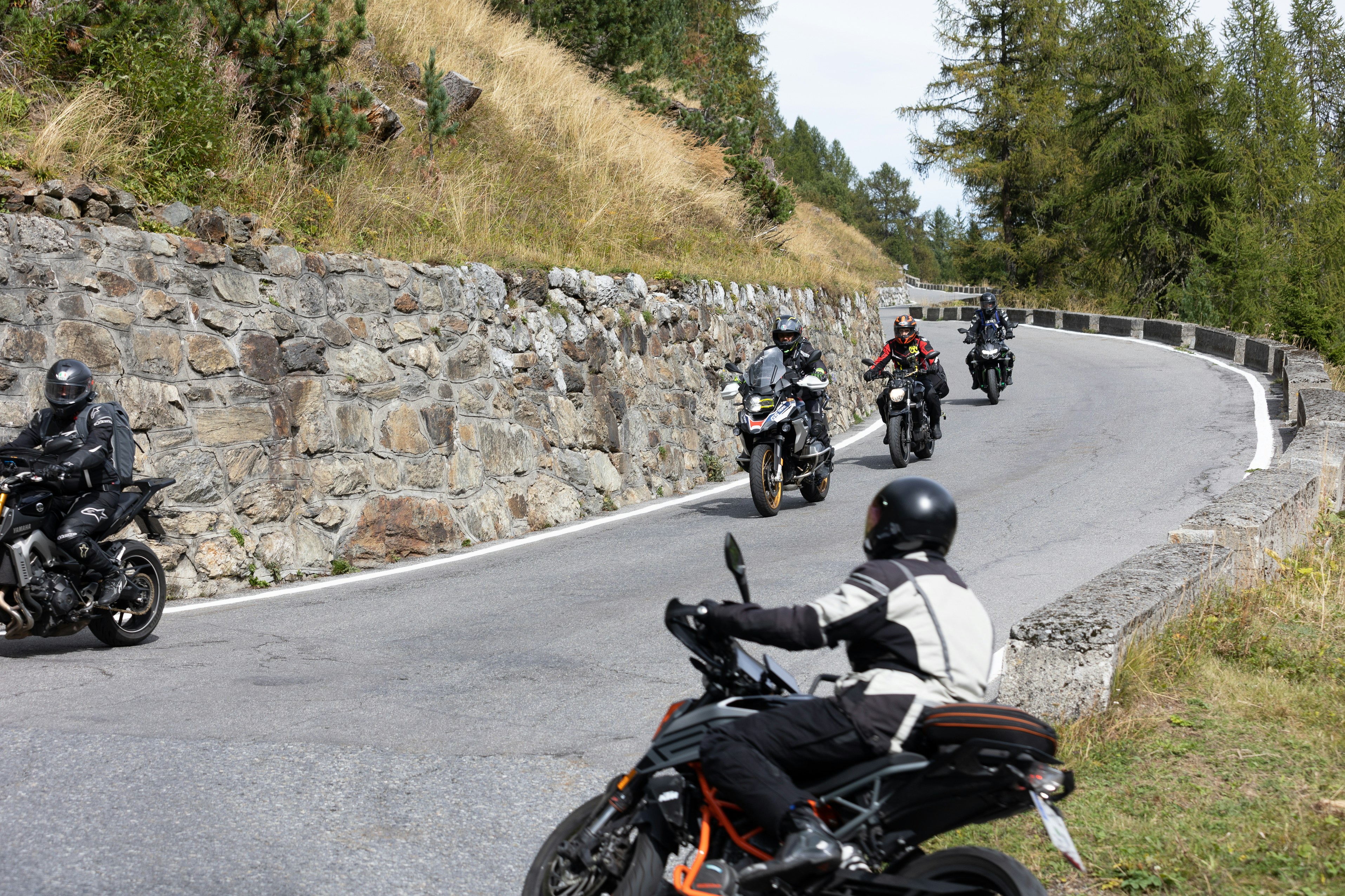 A group of people riding motorcycles down a road photo – Free Stelvio ...