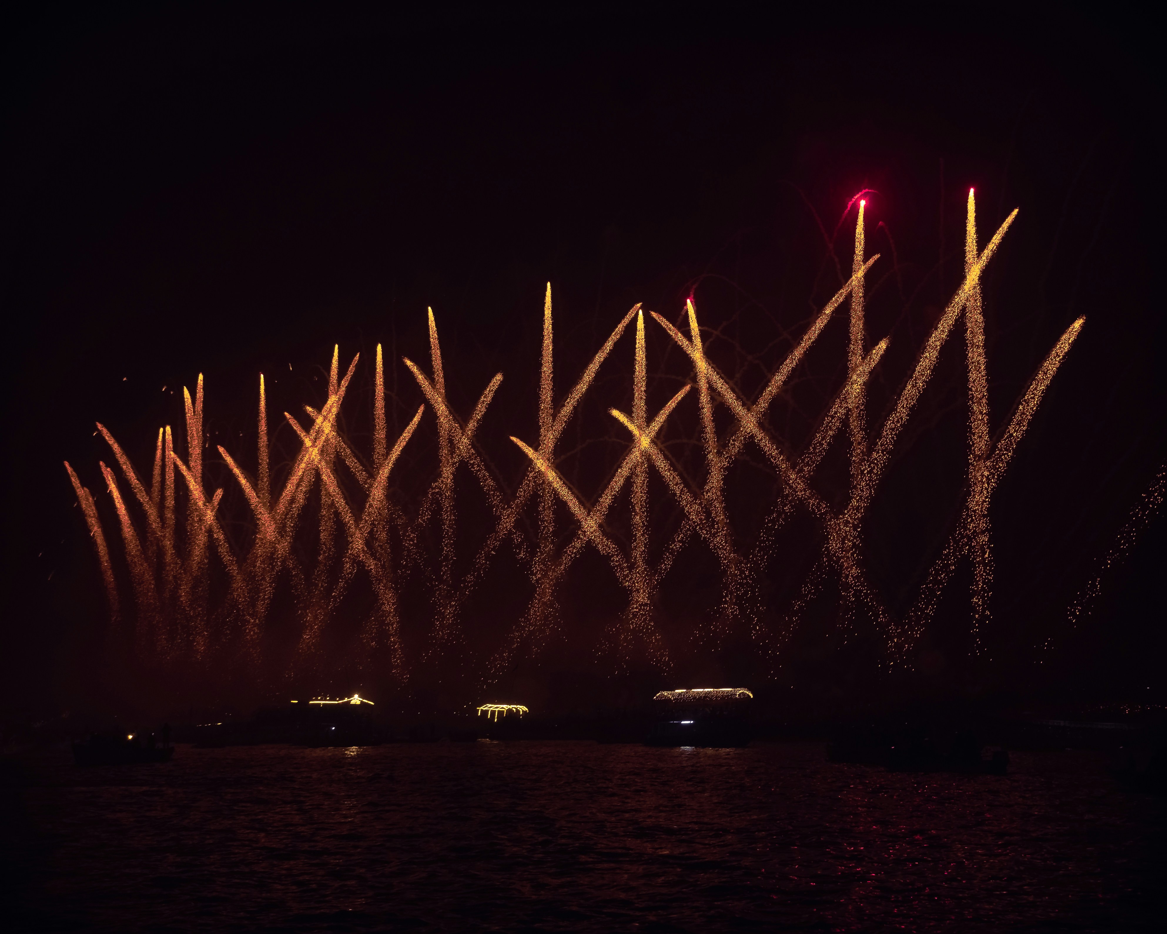 Crisscrossing Crimson Arcs Over a Quiet Harbor