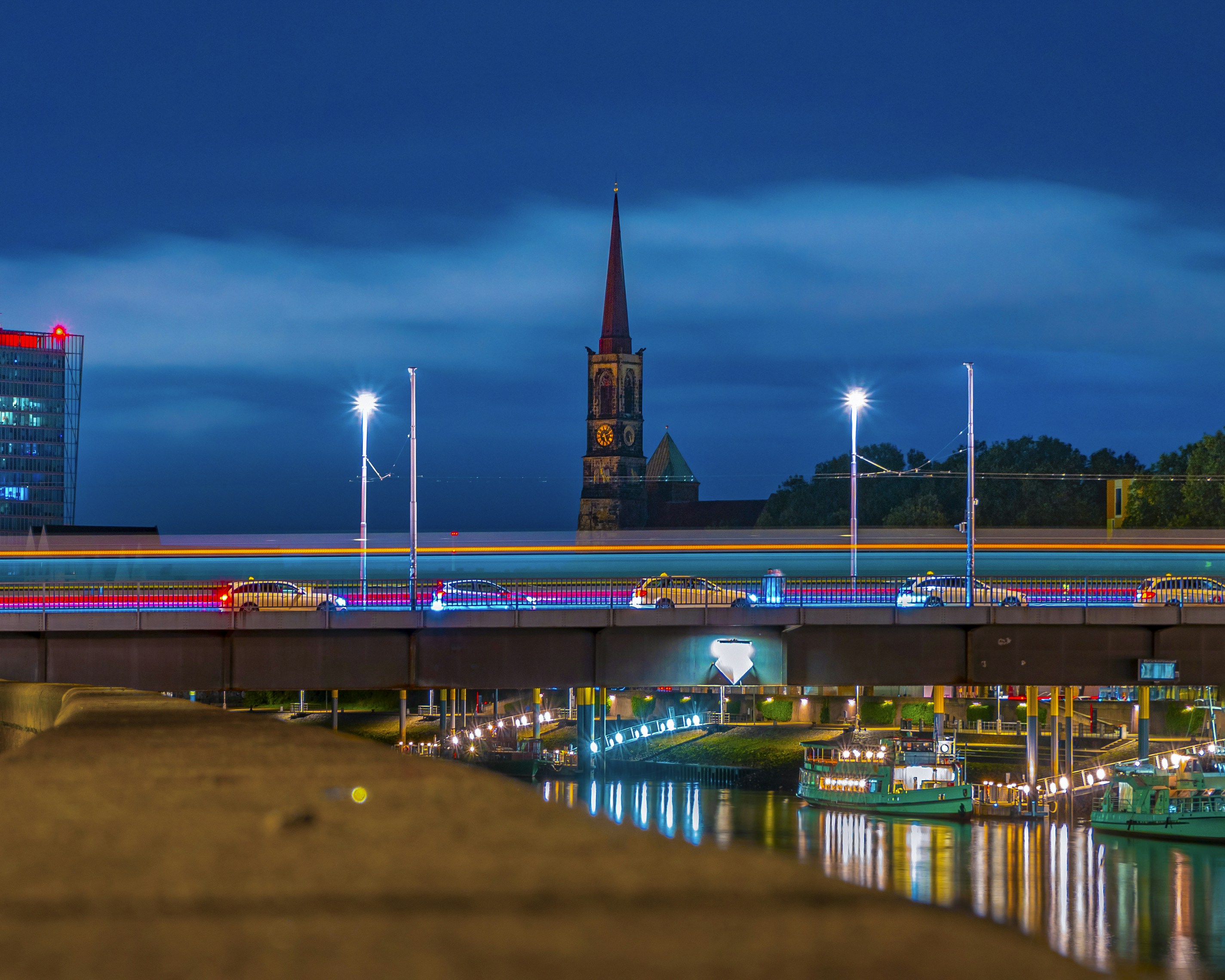 A bridge over a river with a clock tower in the background photo – Free ...