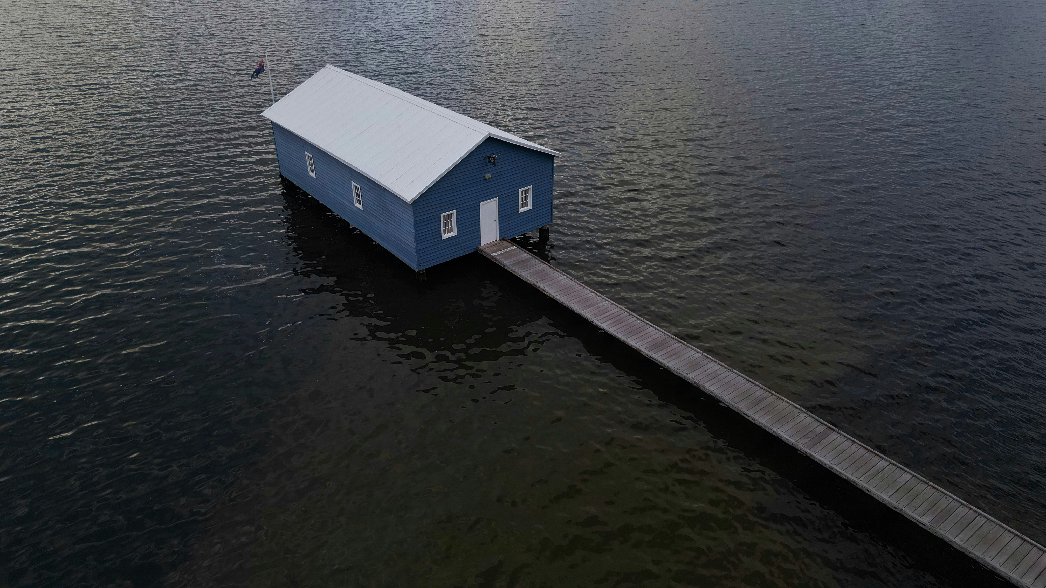 Blue Boathouse at the End of a Long Dock: An Aerial View