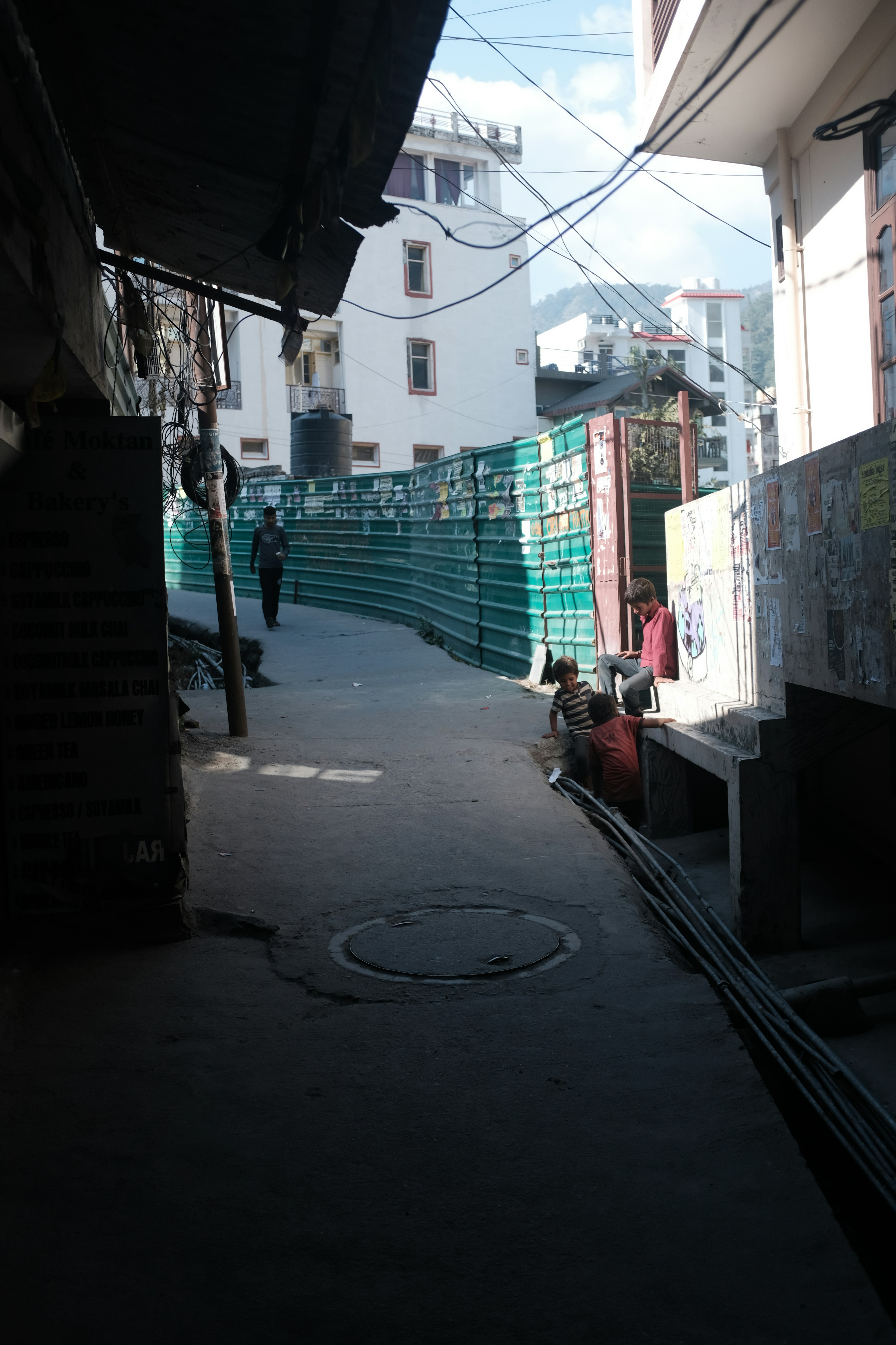 A person sitting on a bench in the middle of a street photo – Free City ...