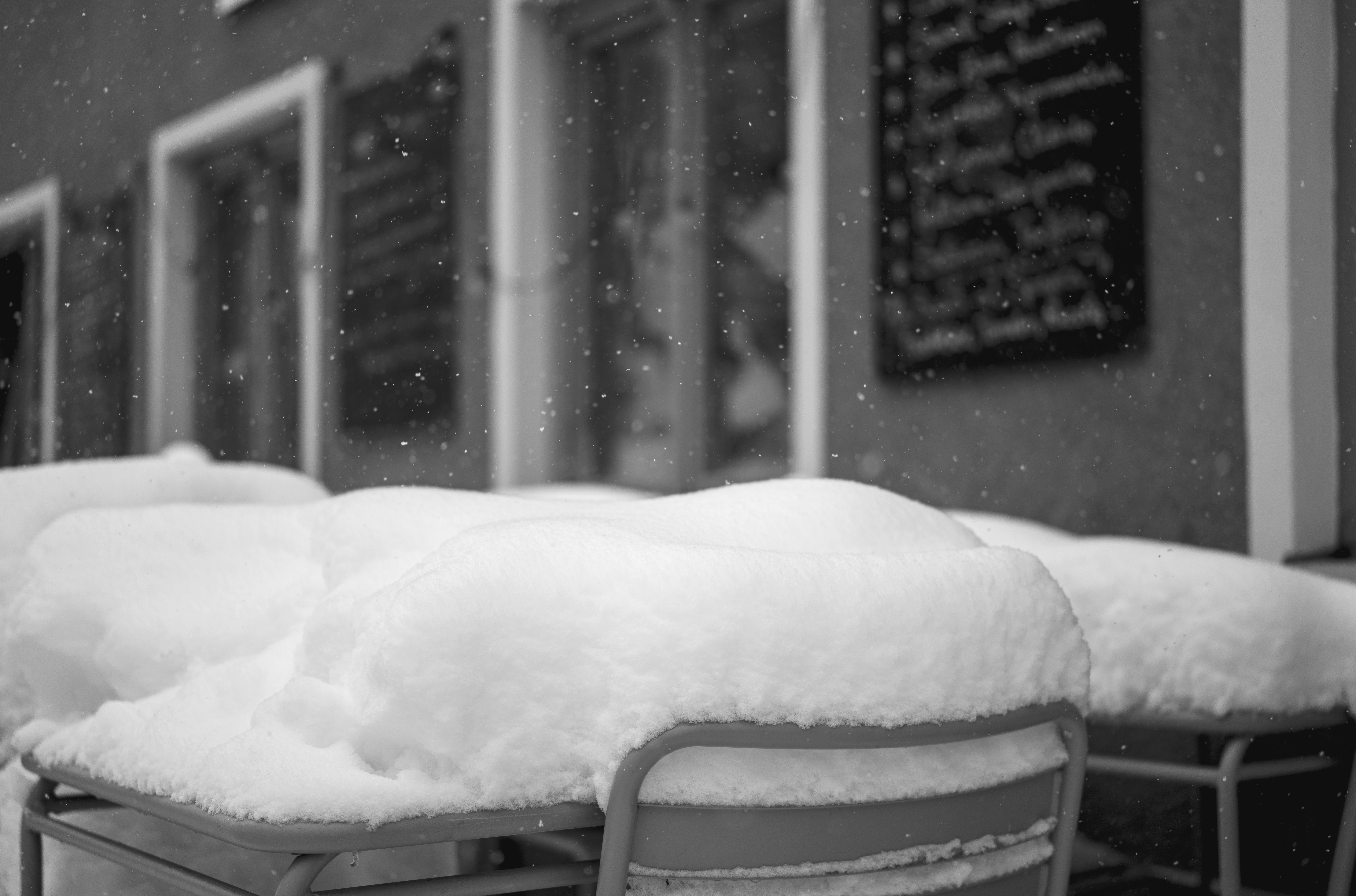 Snow-Laden Chairs at a Quiet Café